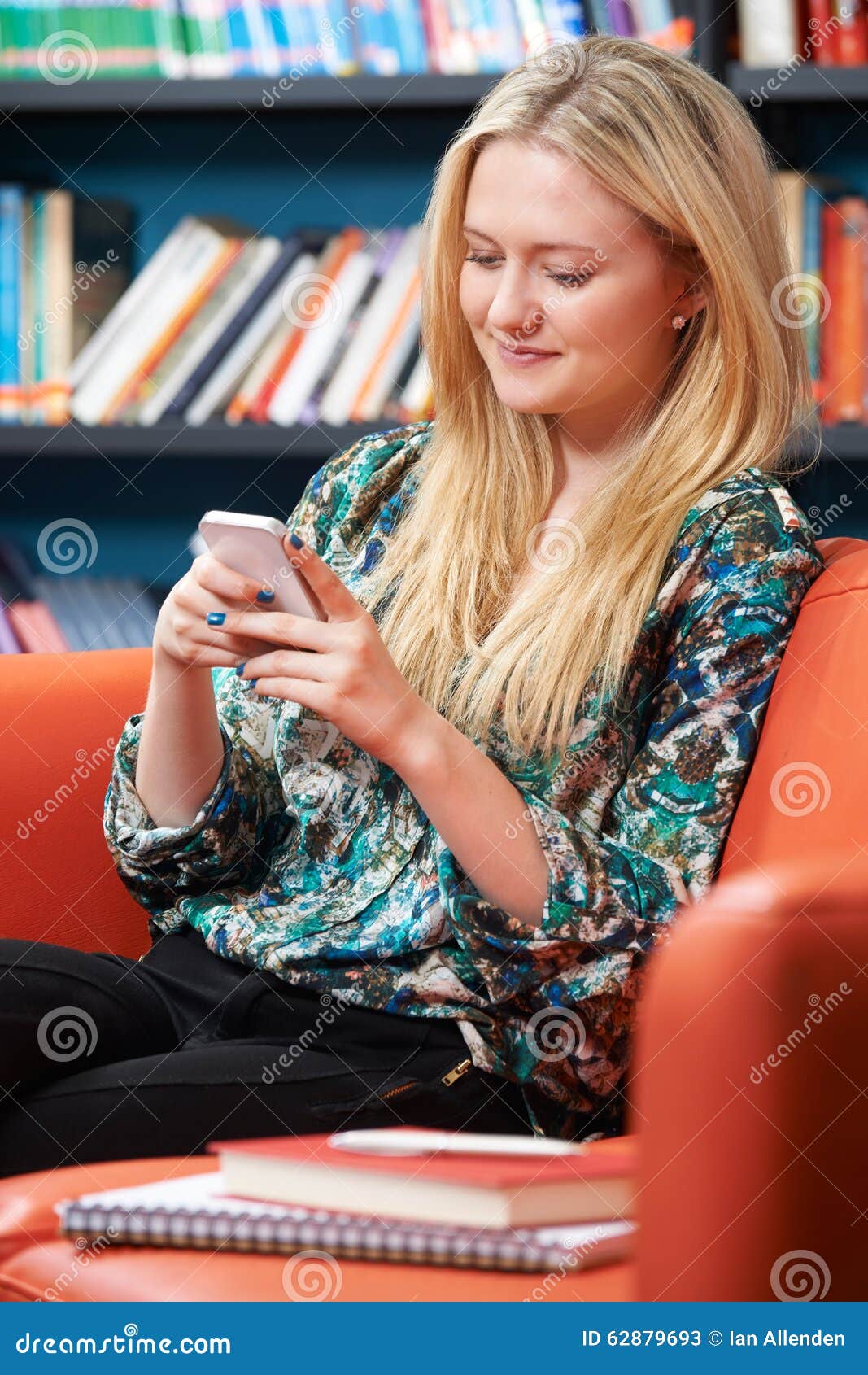 Female Teenage Student Using Mobile Phone in Library Stock Image ...