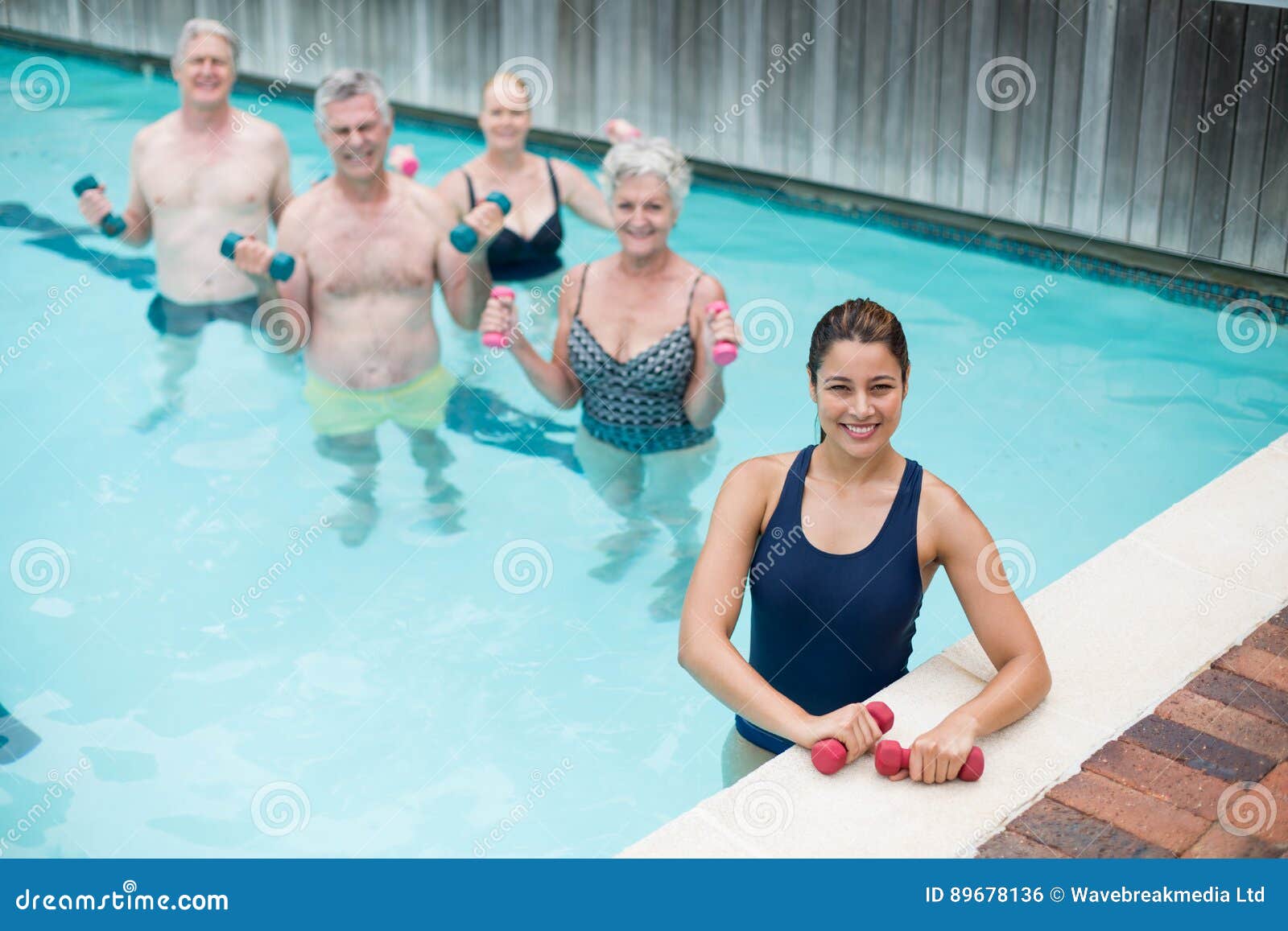 Female Trainer with Senior Swimmers Standing in Pool Stock Photo ...