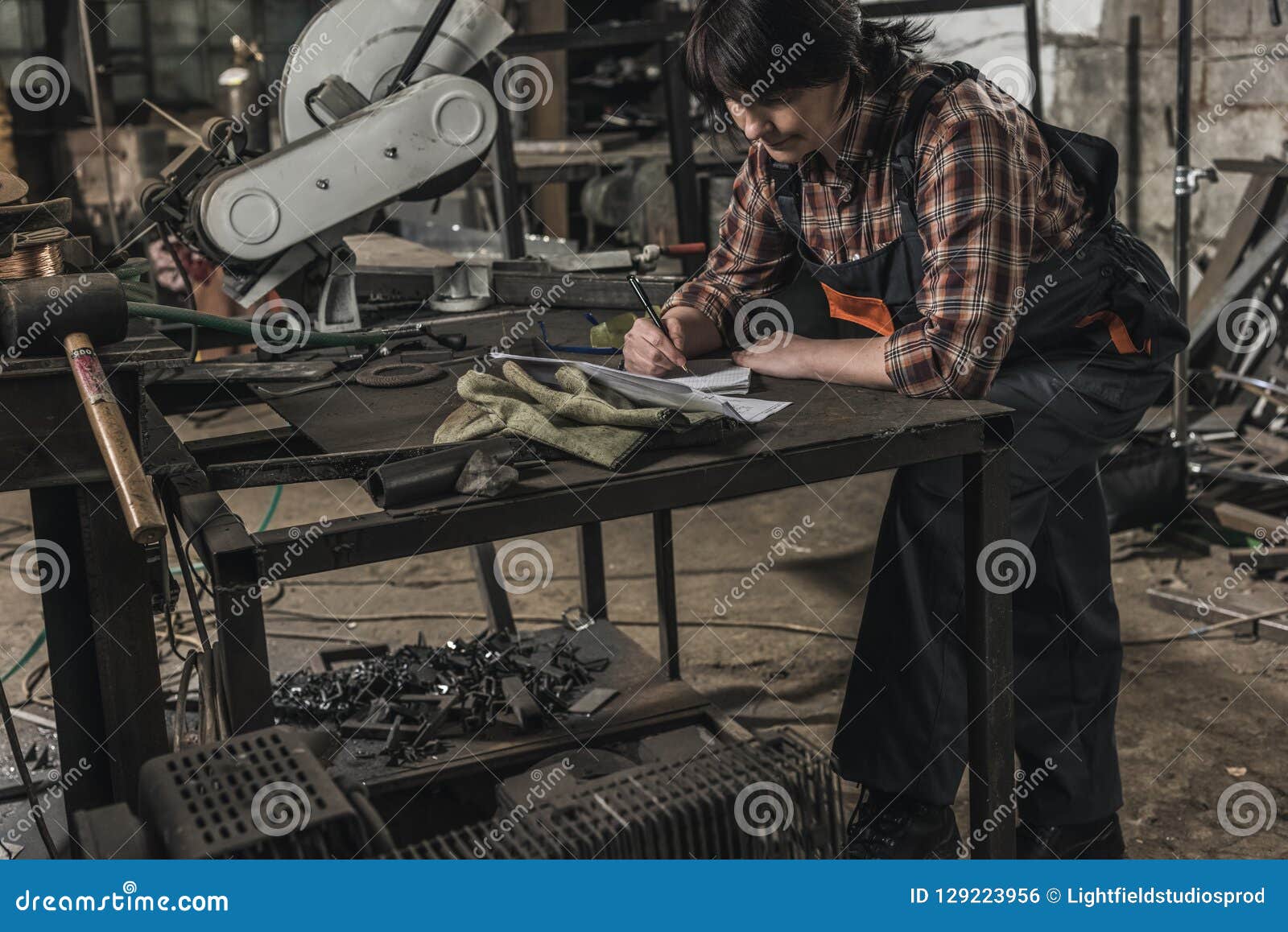 Female Welder Doing Paperwork at Table Stock Photo - Image of ...