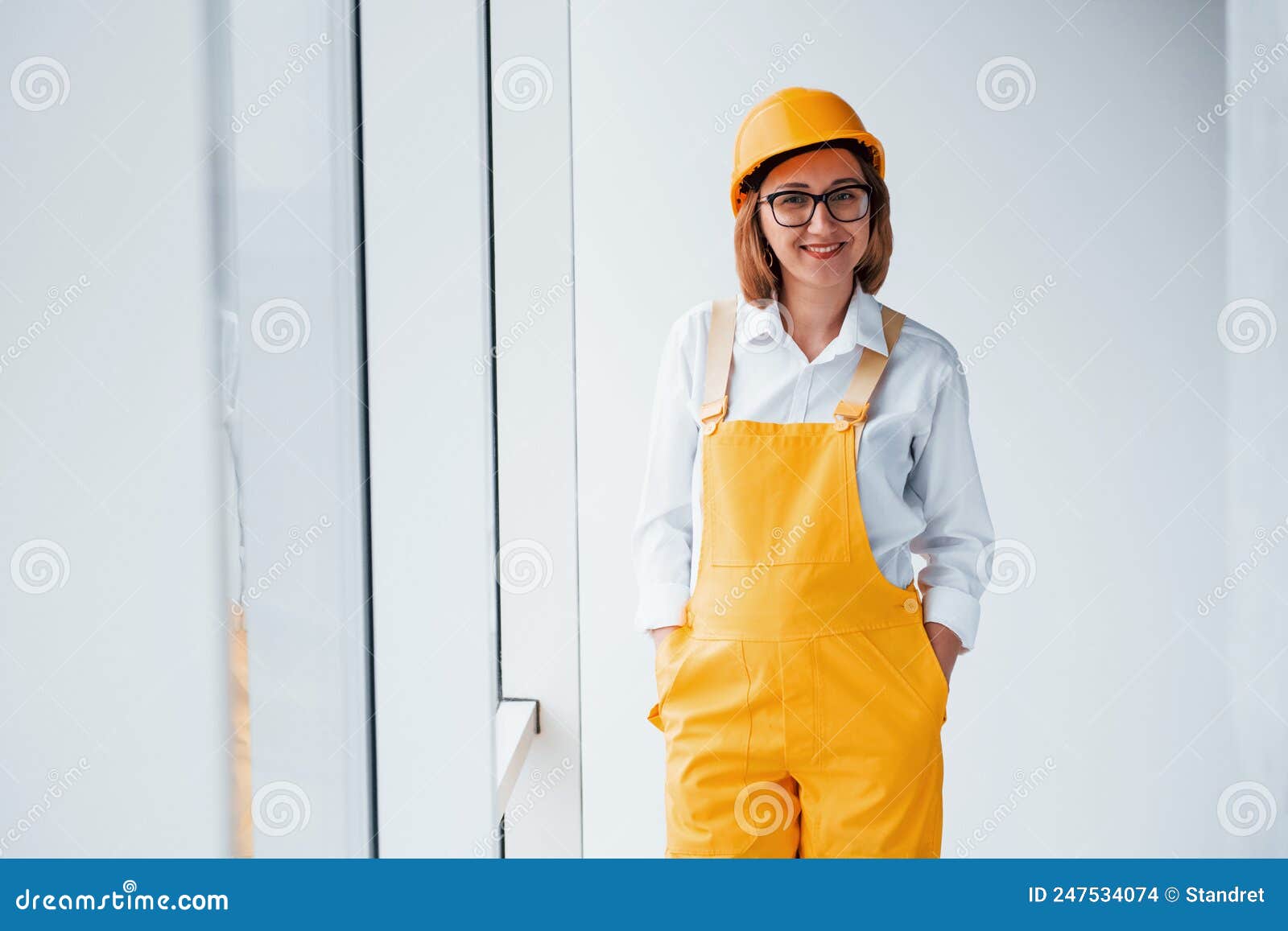Female Worker or Engineer in Yellow Uniform and Hard Hat Standing ...