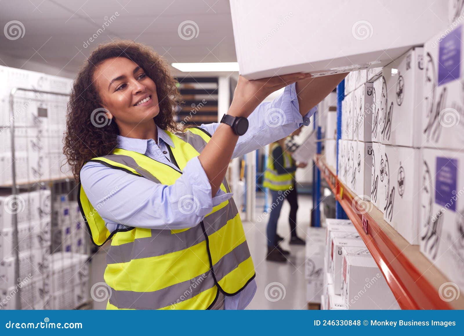 Female Worker Inside Busy Warehouse Putting Box Onto Shelf Stock Photo ...