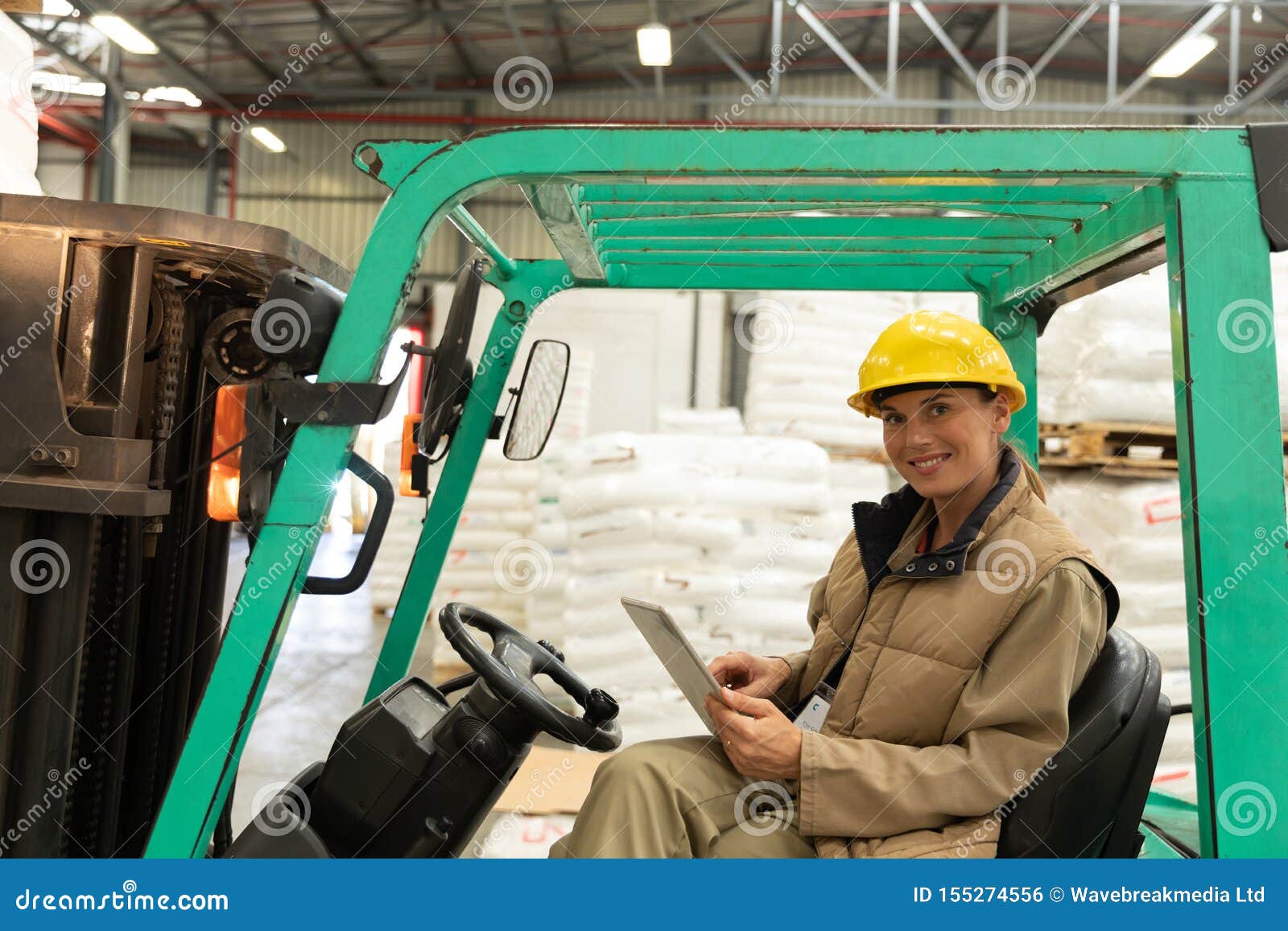 Female Worker Using Digital Tablet while Sitting in Forklift in ...