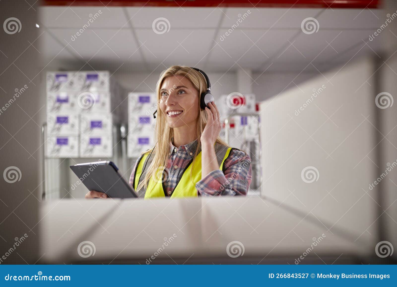 Female Worker Wearing Headset in Logistics Distribution Warehouse with ...