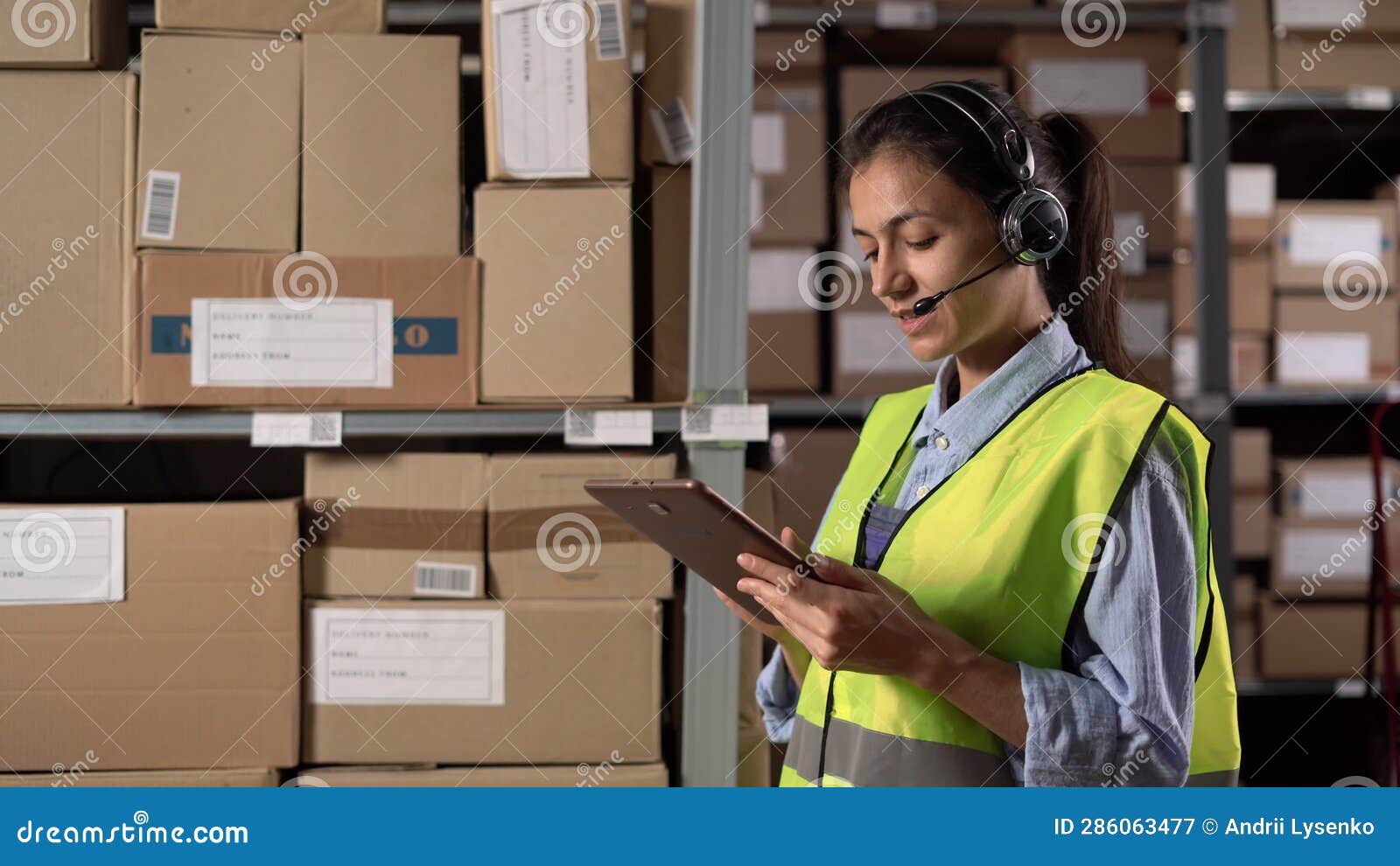 Female Worker Wearing Headset Walking in Logistics Distribution ...