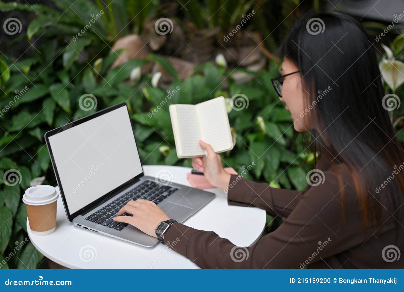 Female Worker Working with Laptop and Notebook on Round Table at Cafe ...