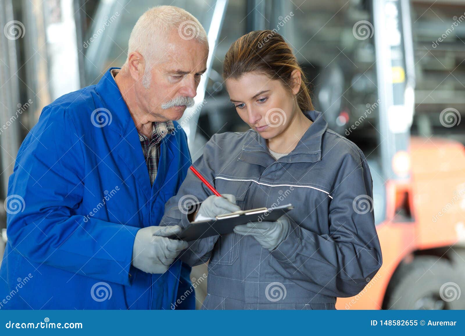 Female Worker Writing on Clipboard Under Supervision Foreman Stock ...