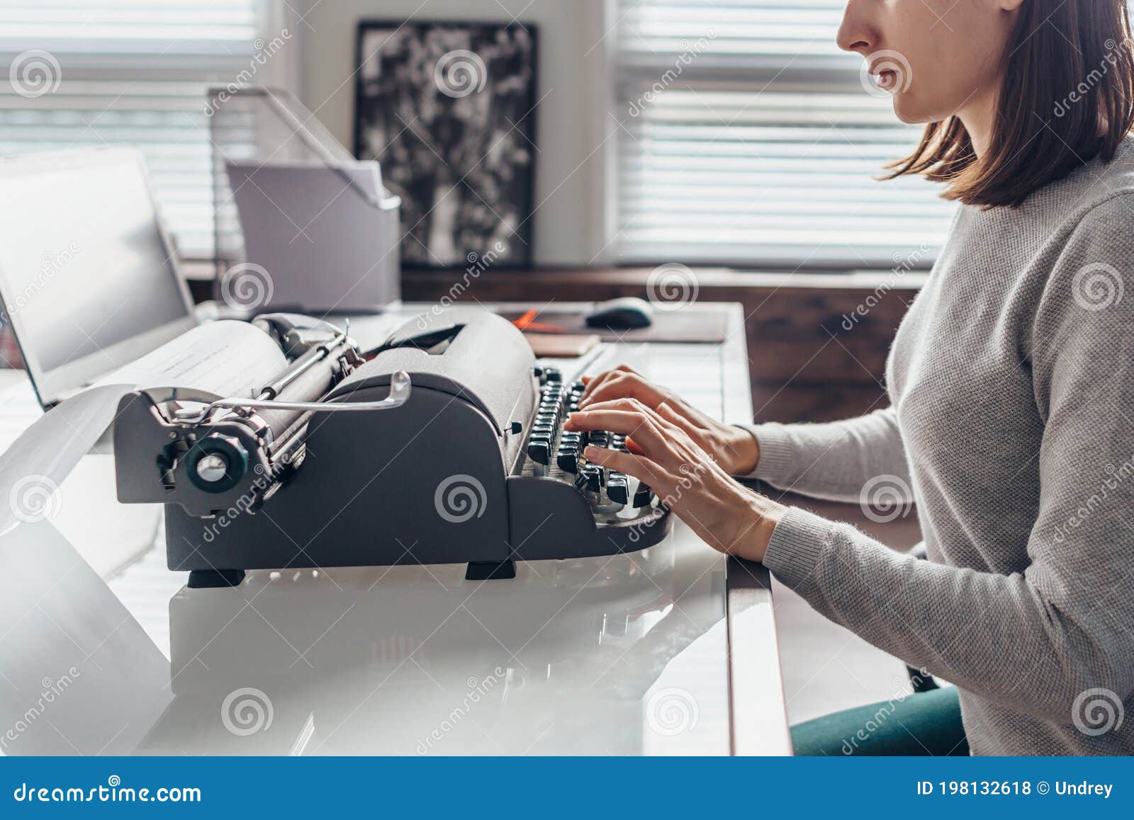 Female Writer Typing on a Typewriter Sitting in Her Workroom. Stock ...