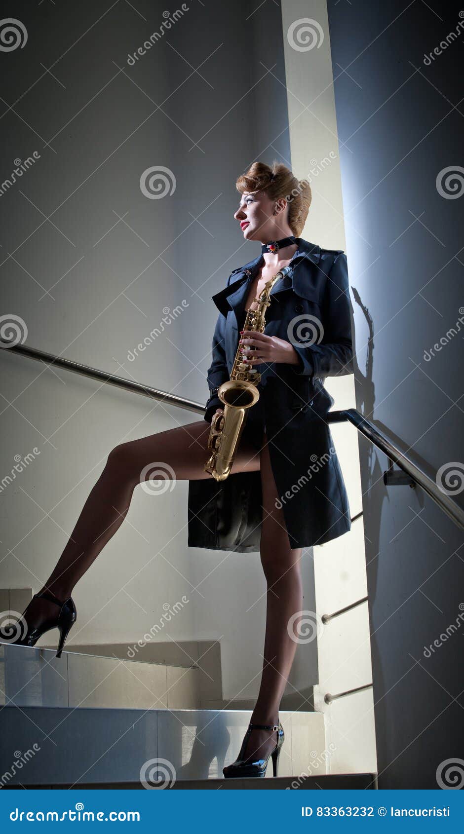 Femme Attirante Sexy Avec Le Saxophone Et Les Longues Jambes Posant Sur