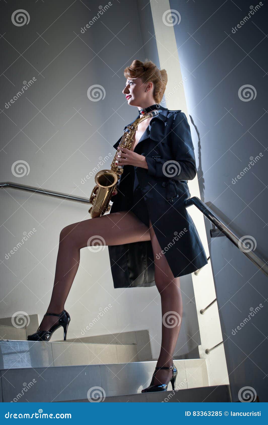Femme Attirante Sexy Avec Le Saxophone Et Les Longues Jambes Posant Sur