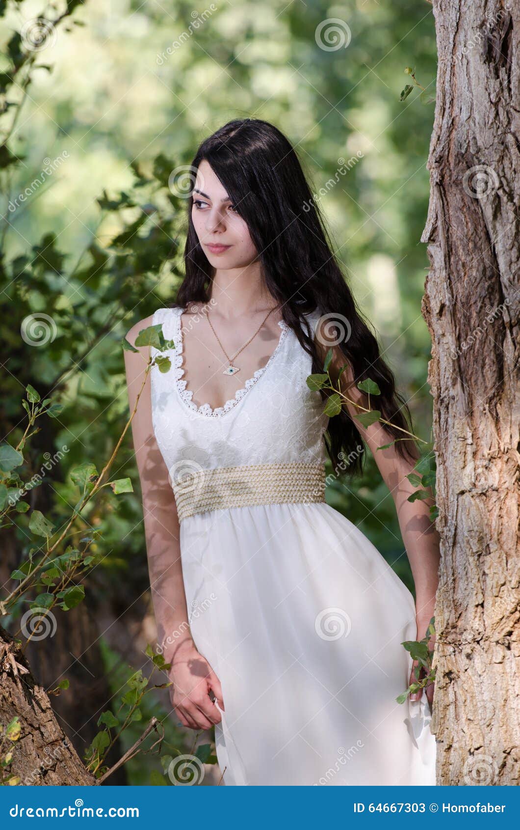 Femme Avec La Robe Blanche De Port De Longs Cheveux Pose Dans La Forêt