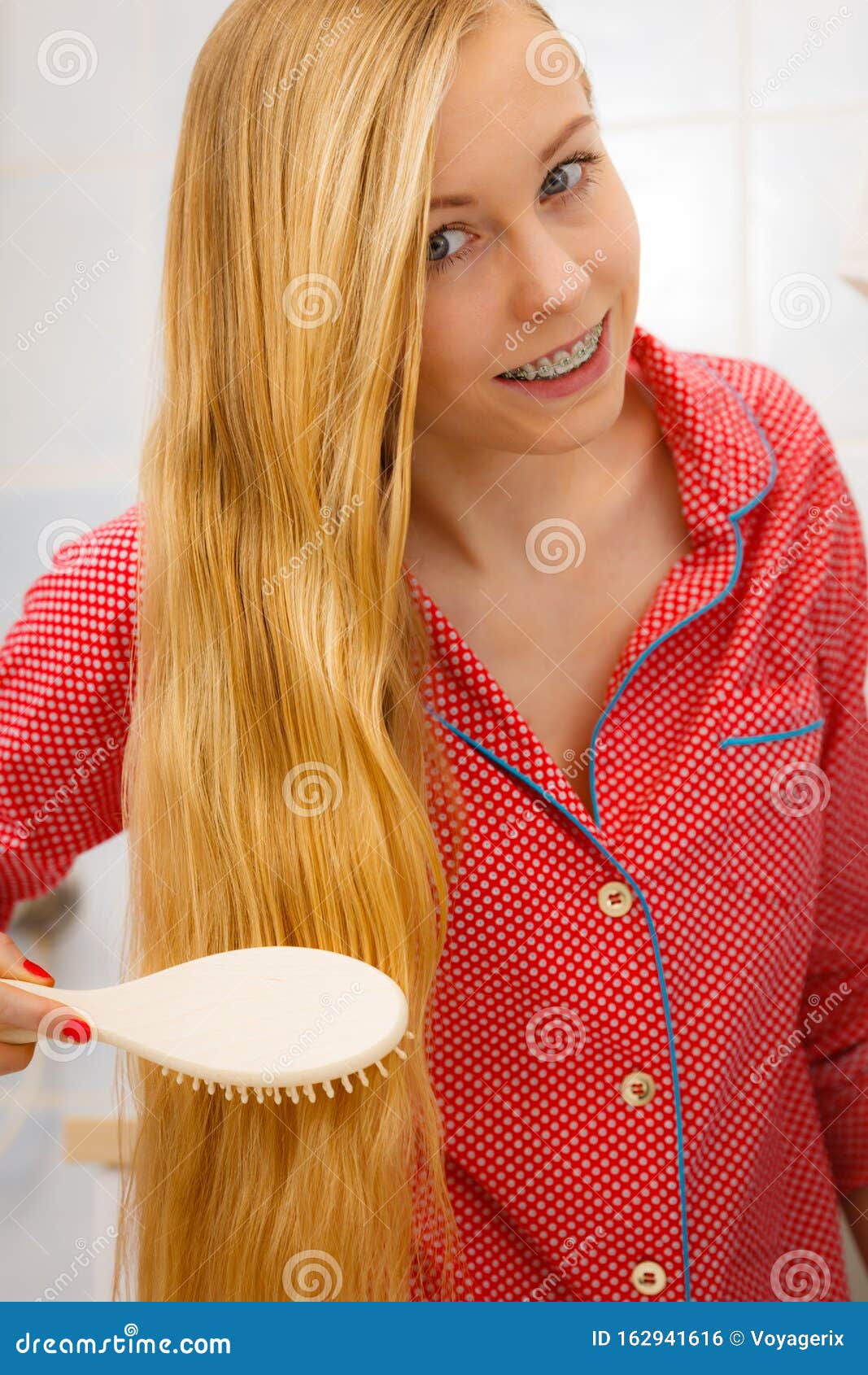 Femme Se Brossant Les Cheveux Longs Dans Les Toilettes Photo Stock