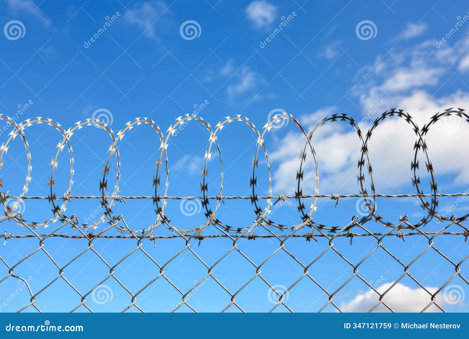 Fence with Barbed Wire Against a Background of Blue Sky, Protected ...
