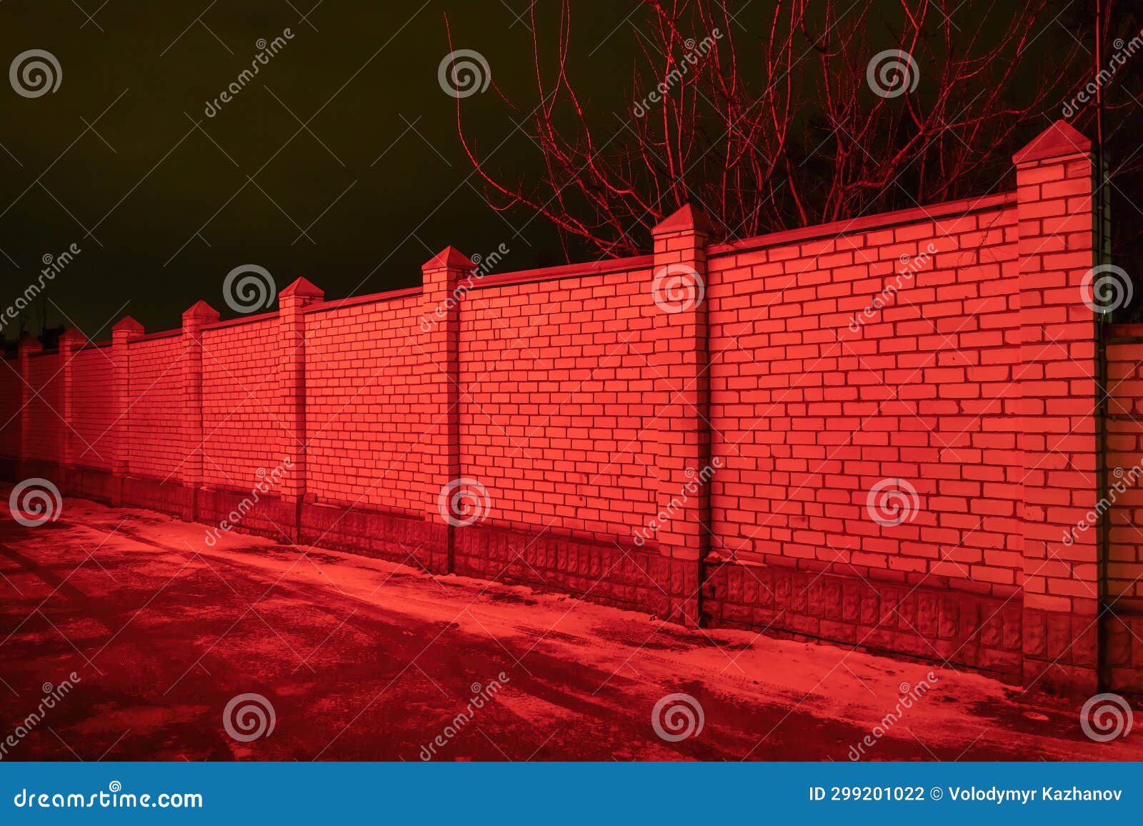 A Fence in the Form of a White Brick Wall is Illuminated with Red Light ...