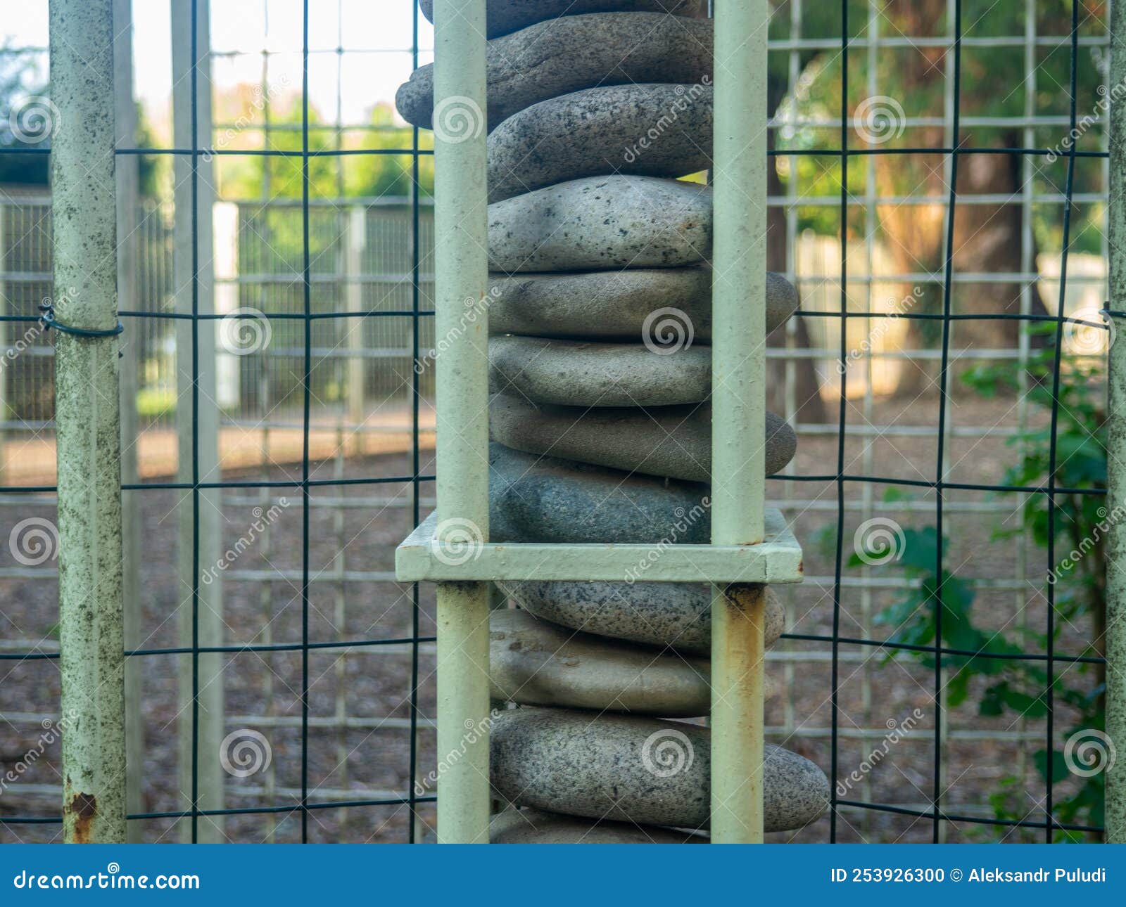 A Fence Made of Rods and Stacked Stones. Stacked Pebbles Stock Photo ...