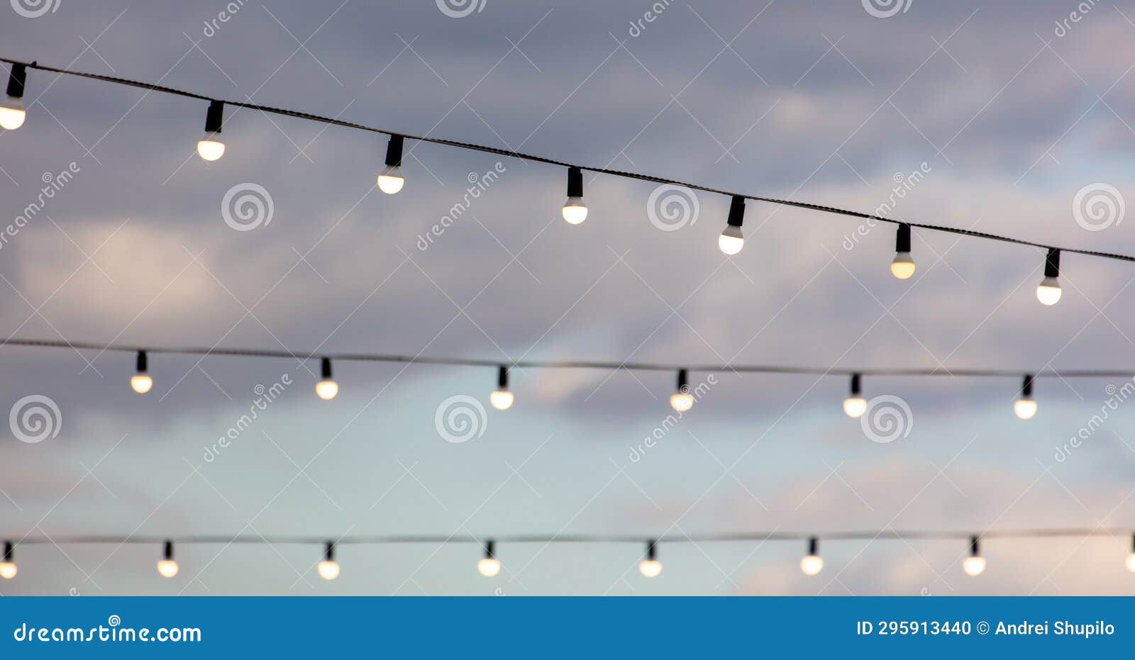 Festive Light Bulbs Shine Against the Background of the Sky with Clouds ...