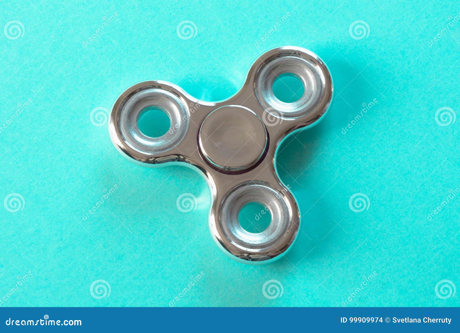 Fidget Silver Finger Glossy Spinner. Flat Lay on Blue. Stock Photo ...