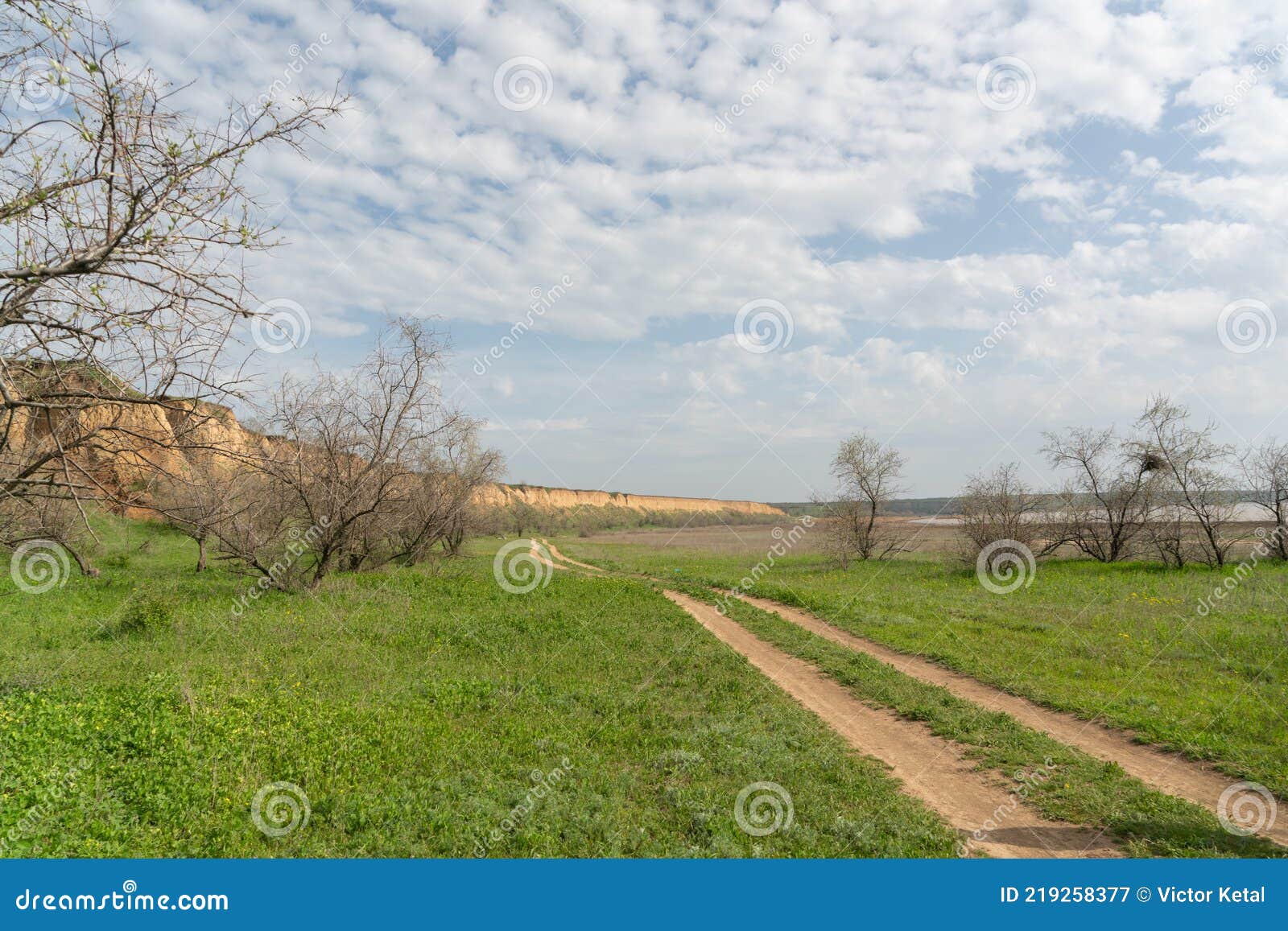 Field Road among Green Grass by the Lake. Beautiful Sky and Clouds ...