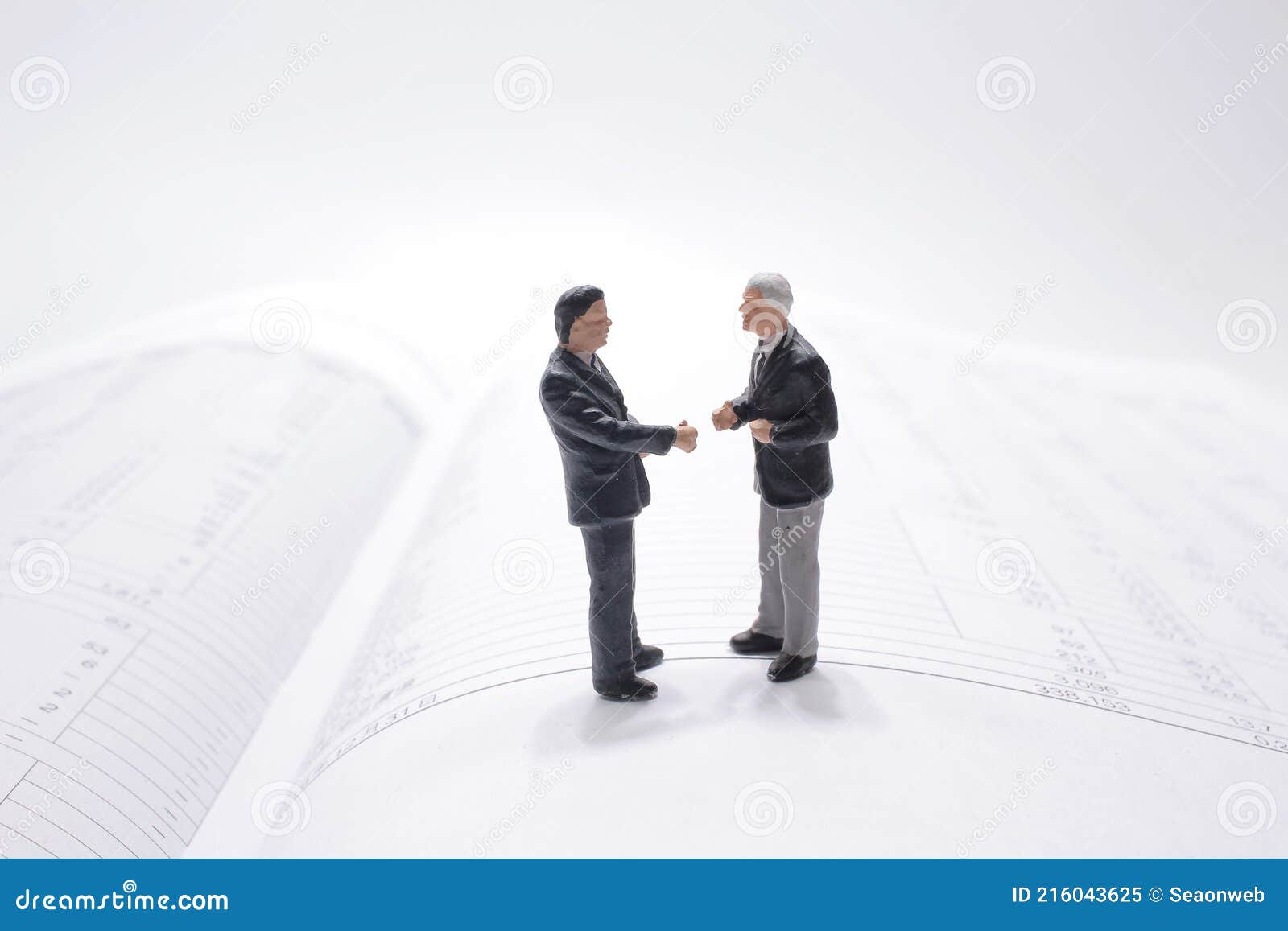 A Figure of Business People Shaking Hands on the Book Stock Image ...