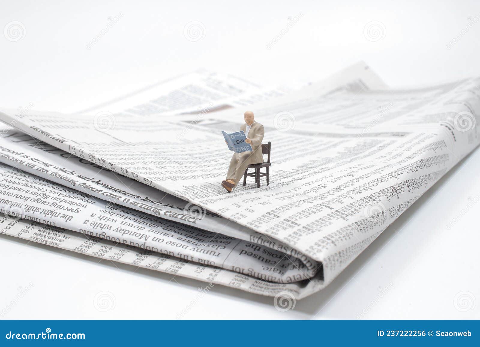 A Figure of a Man Reading while Sitting on a Full Size Newspaper Stock ...
