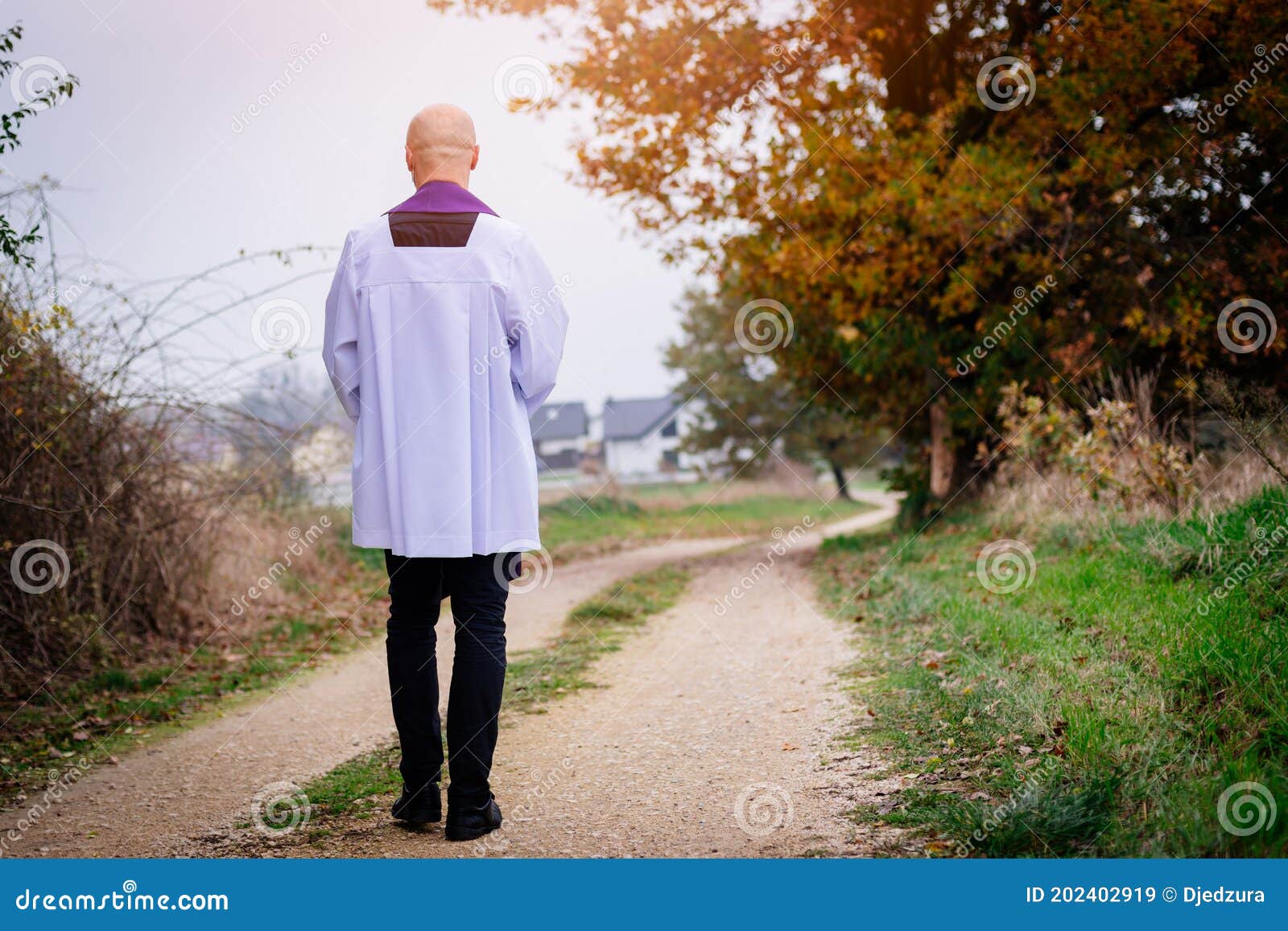 The Figure of a Priest from the Back Walking on a Country Road. Stock ...