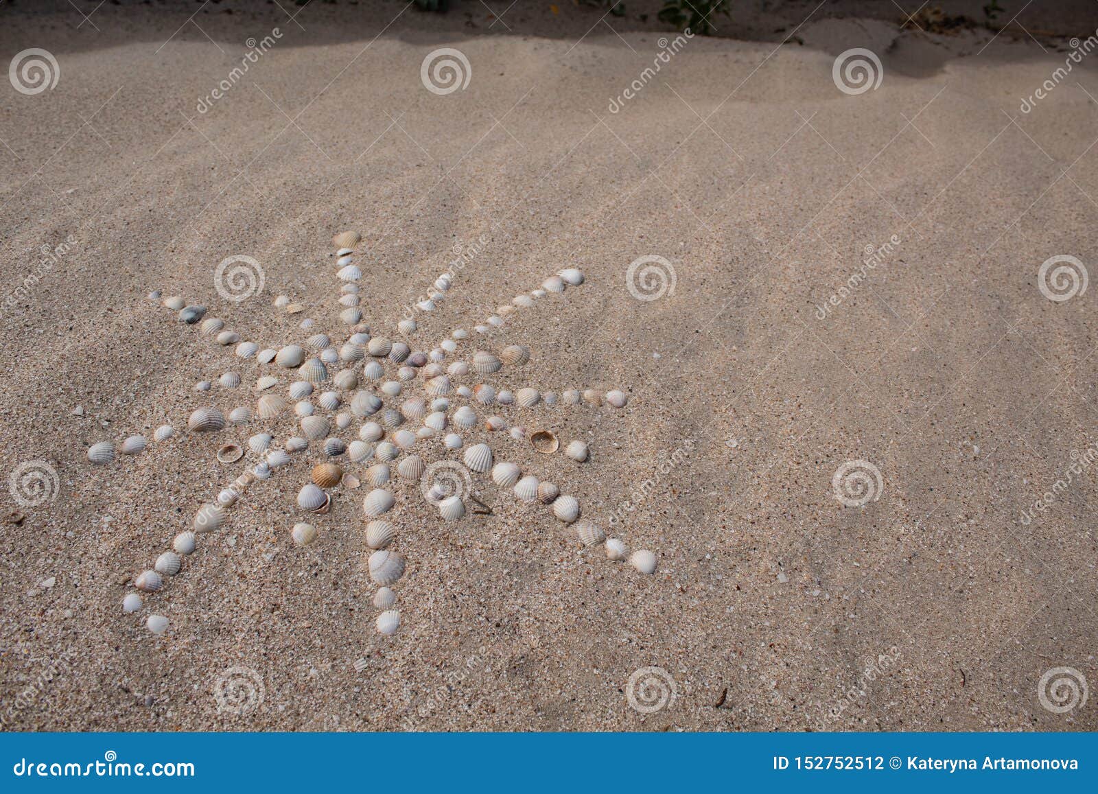 The Figure of the Sun is Laid Out on the Sand with Shells. Stock Photo ...