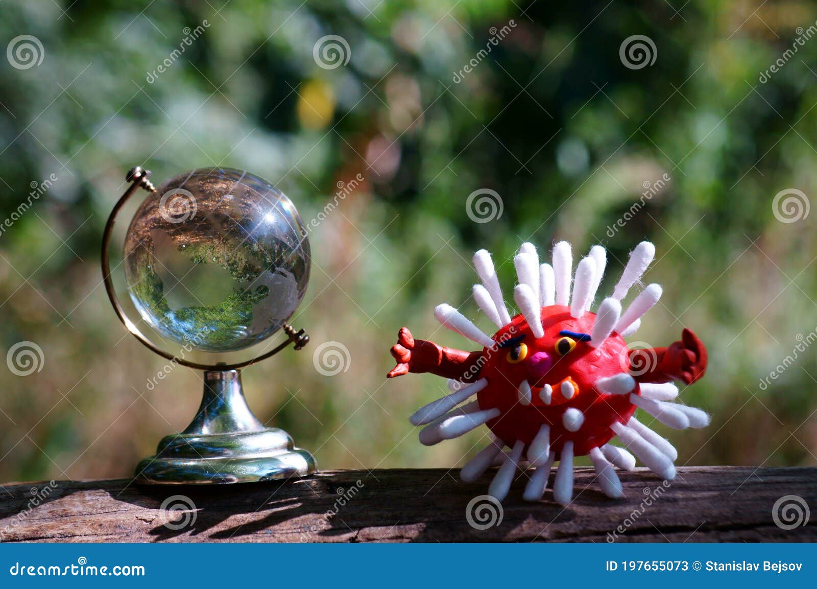 The Figure of the Virus from Clay. Next To it is a Small Glass Globe ...