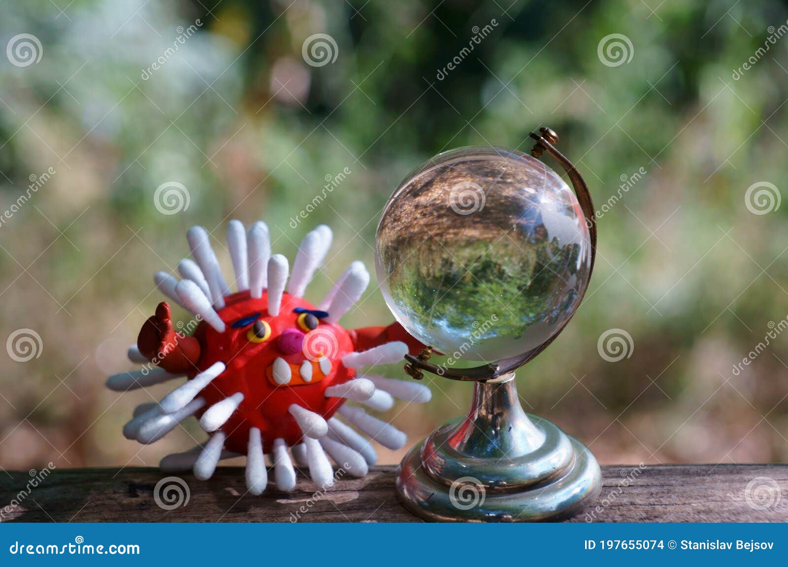 The Figure of the Virus from Clay. Next To it is a Small Glass Globe ...