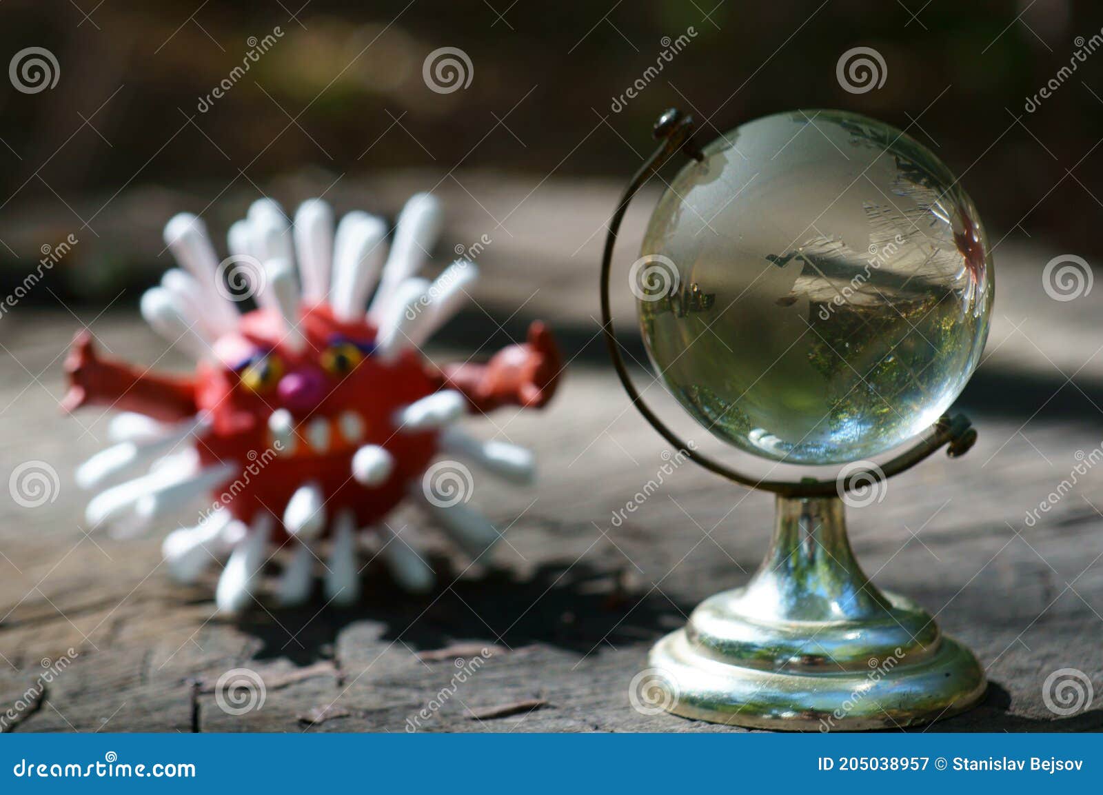 The Figure of the Virus from Clay. Next To it is a Small Glass Globe ...