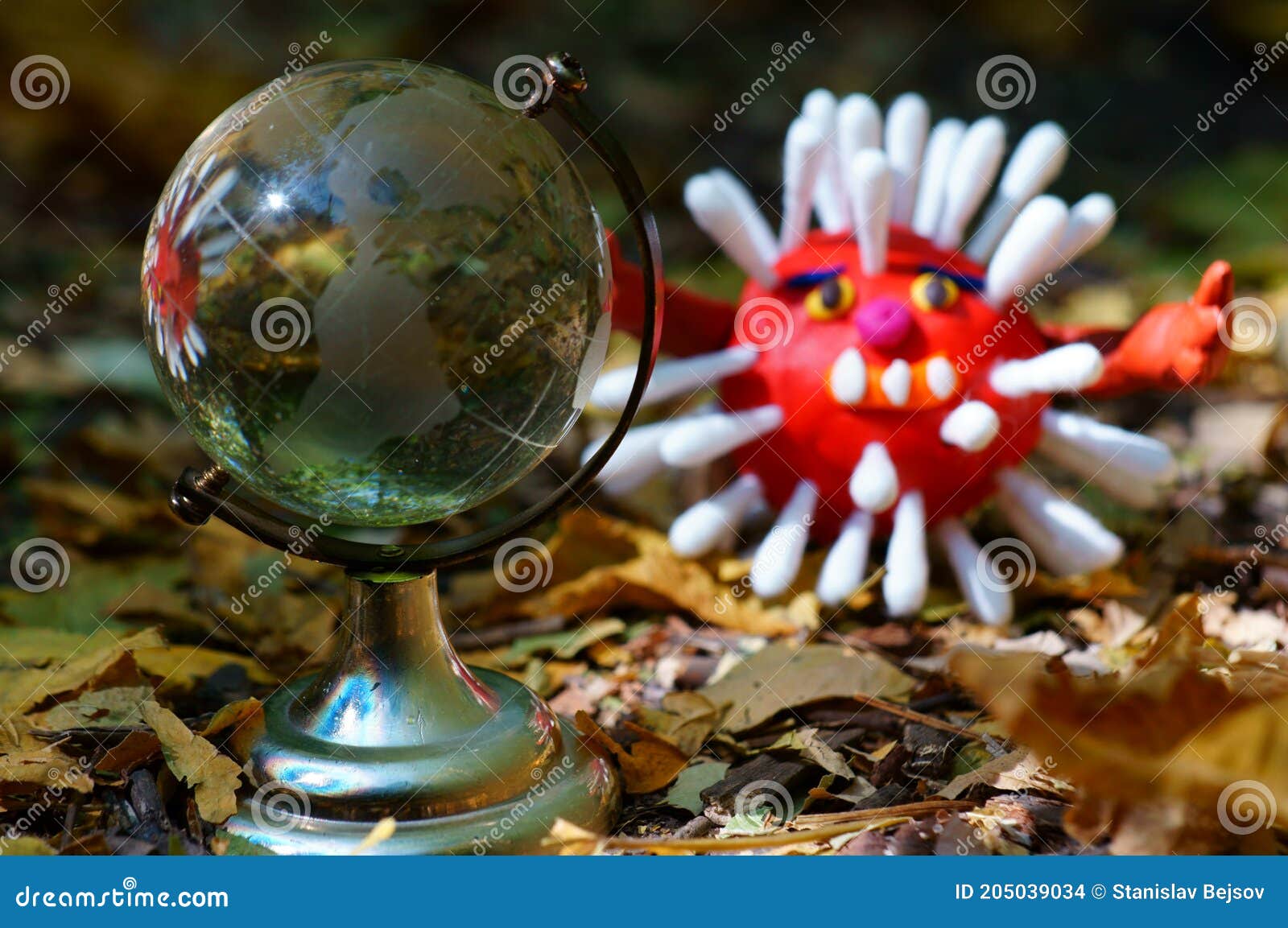 The Figure of the Virus from Clay. Next To it is a Small Glass Globe ...