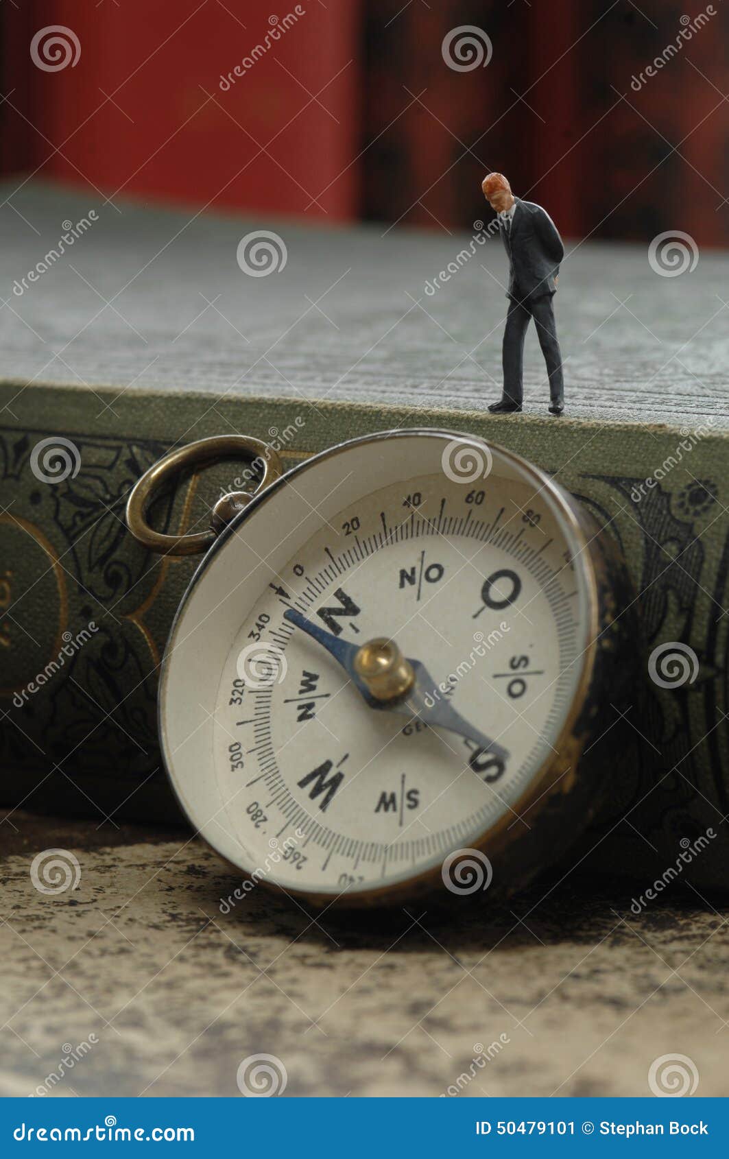 Figurine Standing on Book and Watching at Compass Stock Image - Image ...