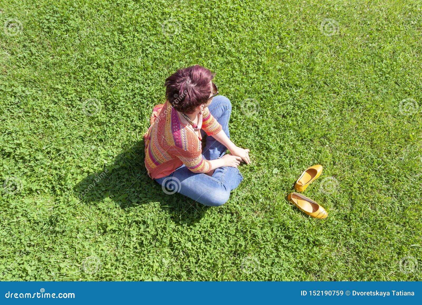 Fille Aux Pieds Nus Sasseyant Sur Lherbe à Côté De Ses Chaussures