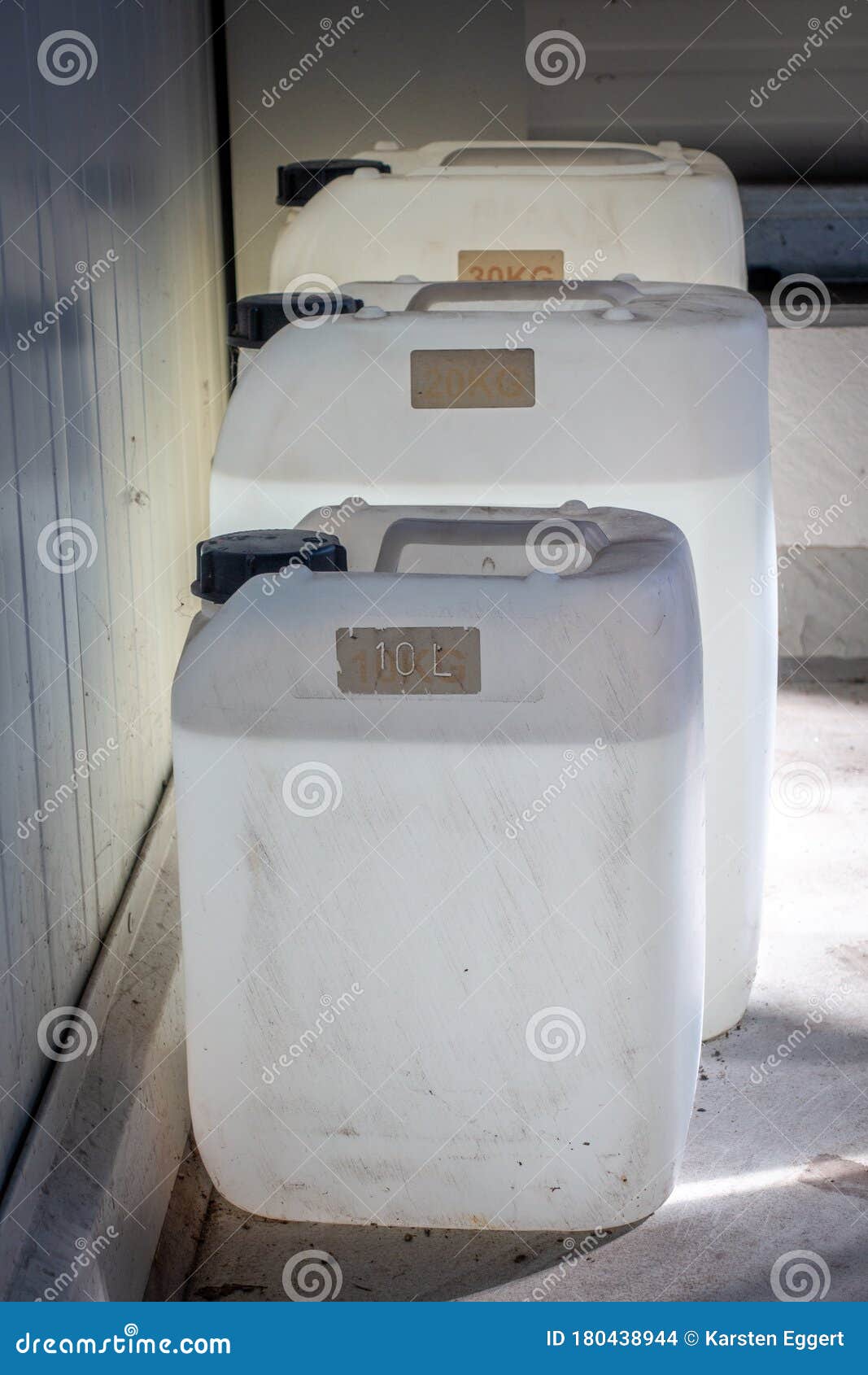 3 Filled White Canisters of Different Sizes Standing on a Wall in a ...