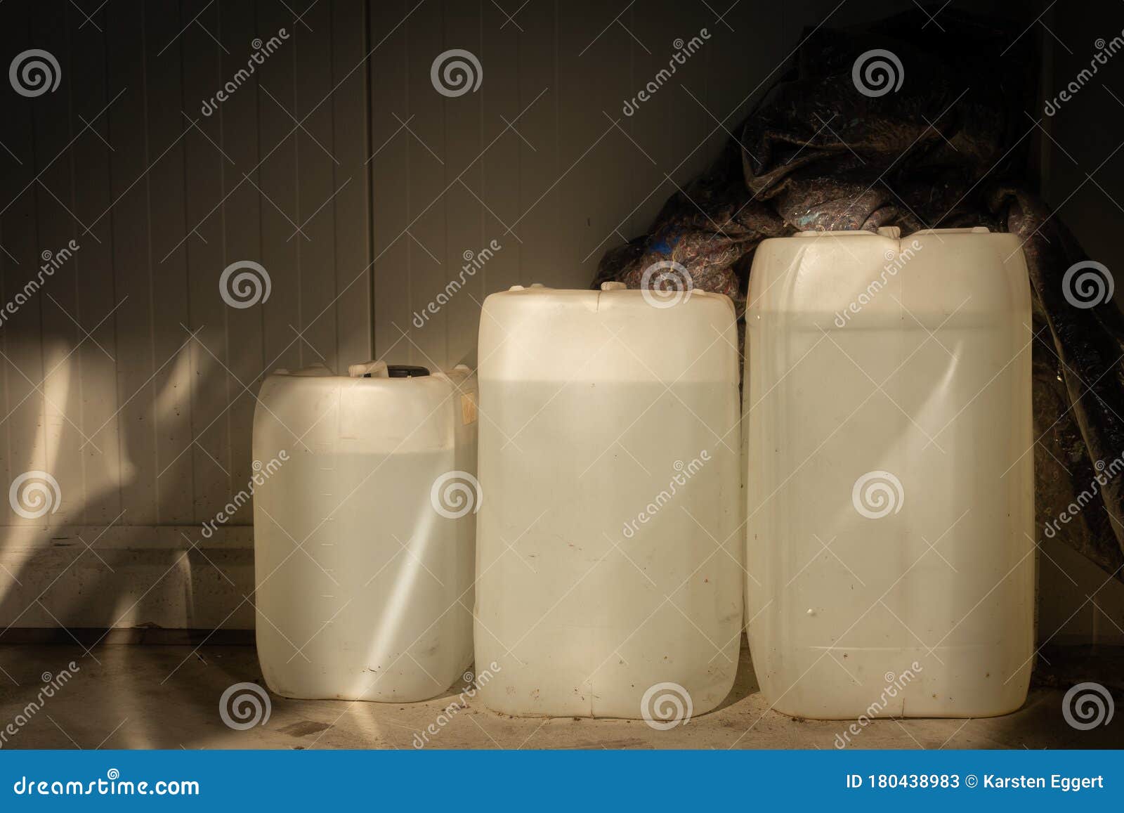 3 Filled White Canisters of Different Sizes Standing on a Wall in a ...