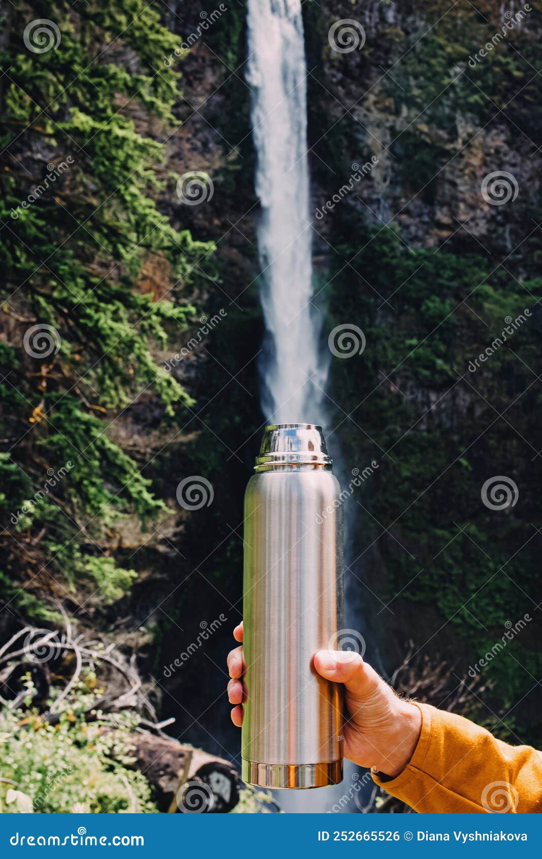 Filling Metal Flask from Waterfall, Optical Illusion Stock Photo ...