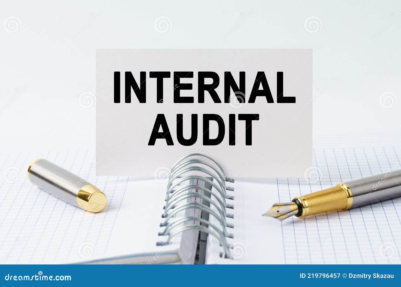 On the Table is a Notebook, a Pen and a Business Card with the ...