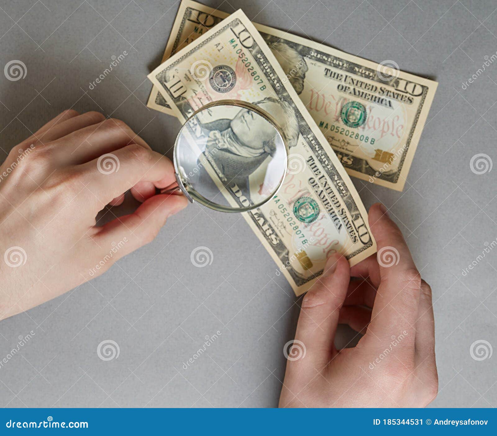 Finance. Hand with a Magnifying Glass Over Paper Banknotes on a Gray ...