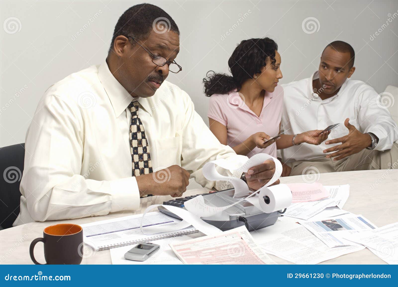 Financial Advisor Holding Expense Receipt with Couple in the Background ...