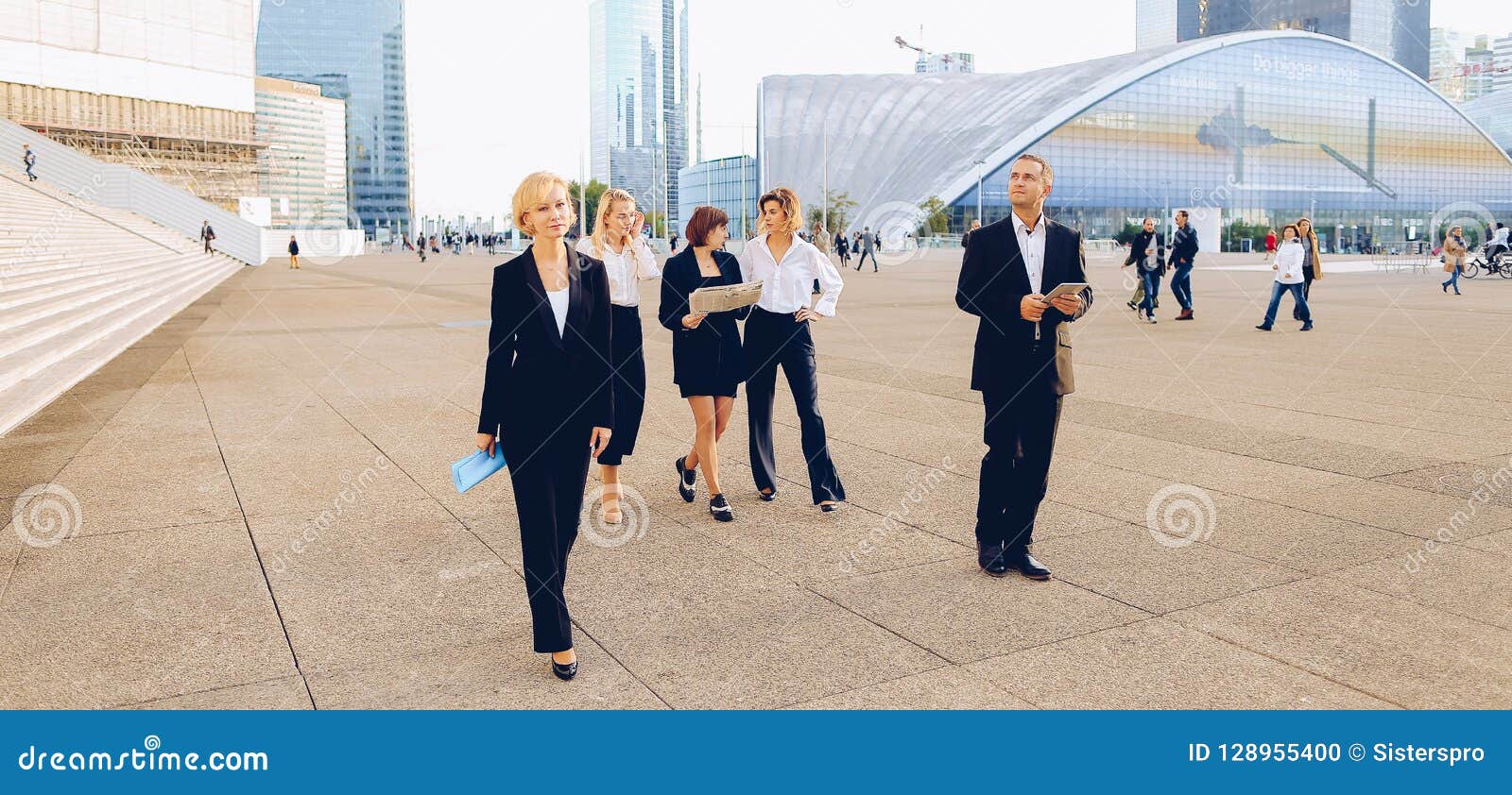 Financial Team Members Passing with Tablet, Cases and Looking at Stock ...