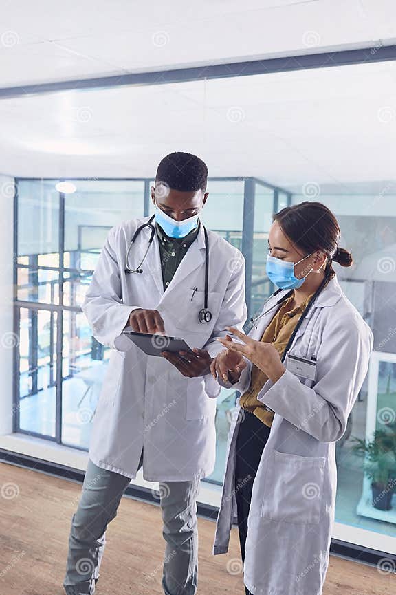 Finding a Solution Together. Two Young Doctors Working on a Digital ...