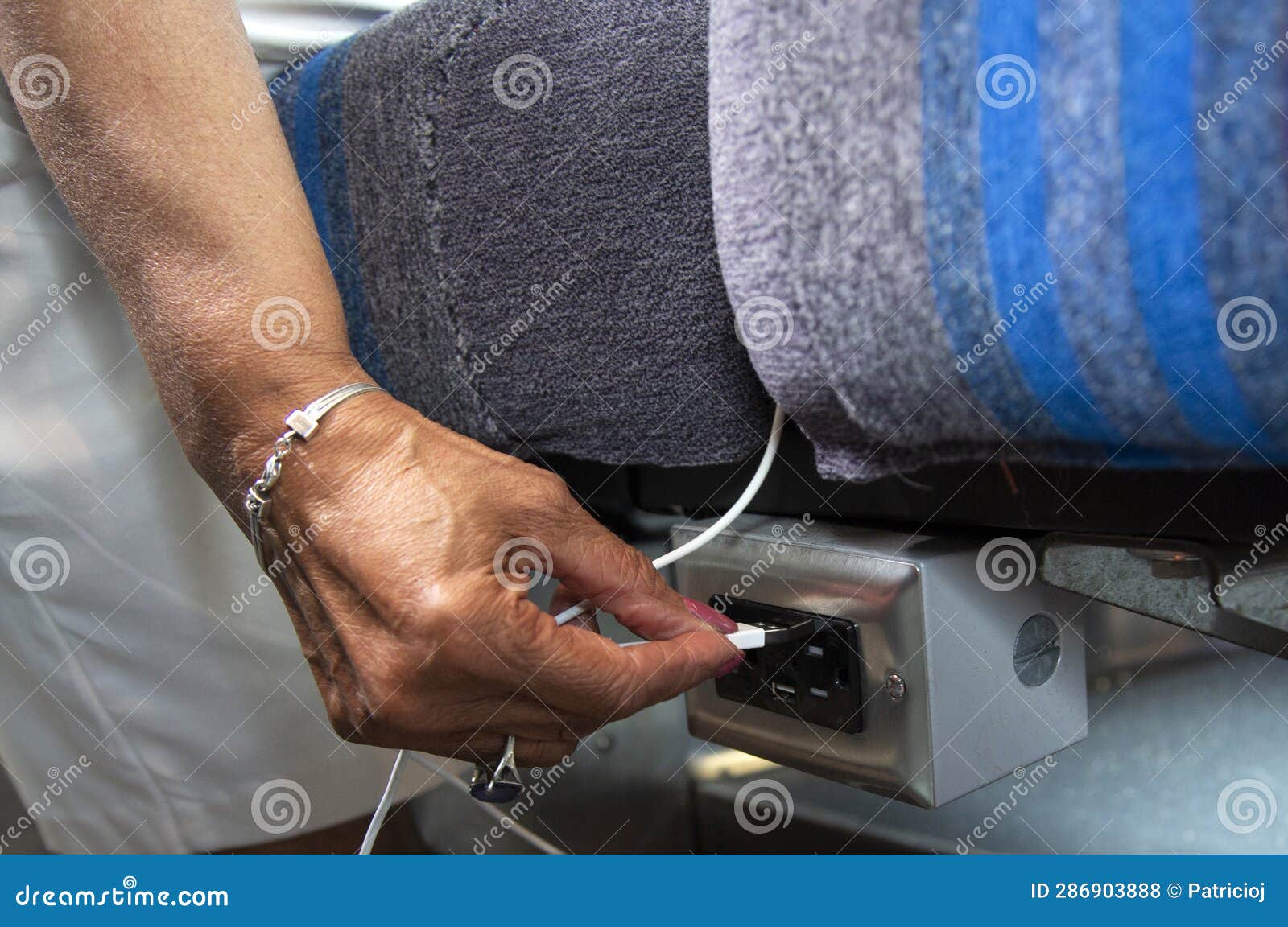 Finger Plugging in a USB Wire Below the Seat of a Bus or Plane Stock ...