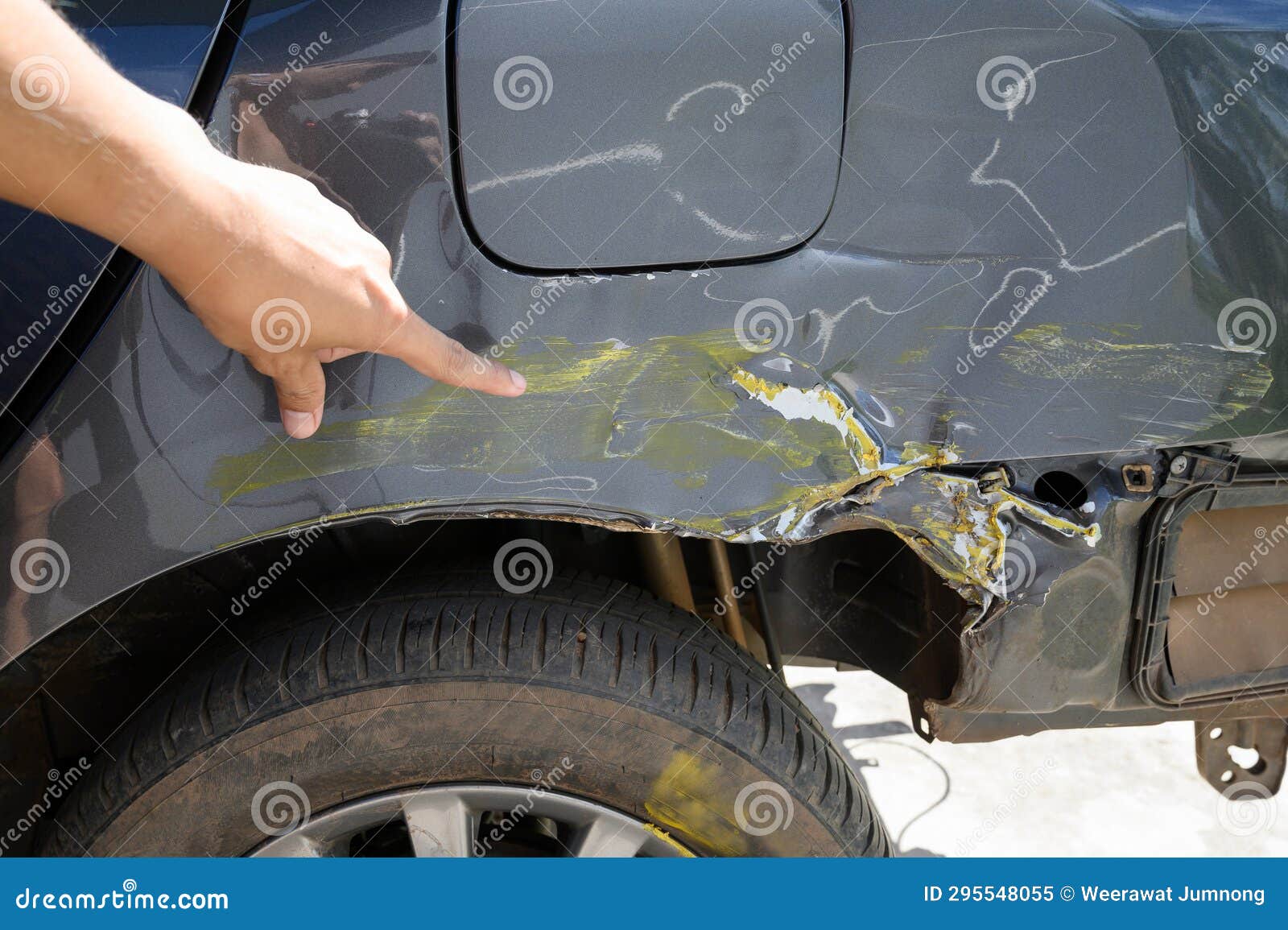 Finger Pointing at Dents on Car from Accident, Damage on the Back Side ...