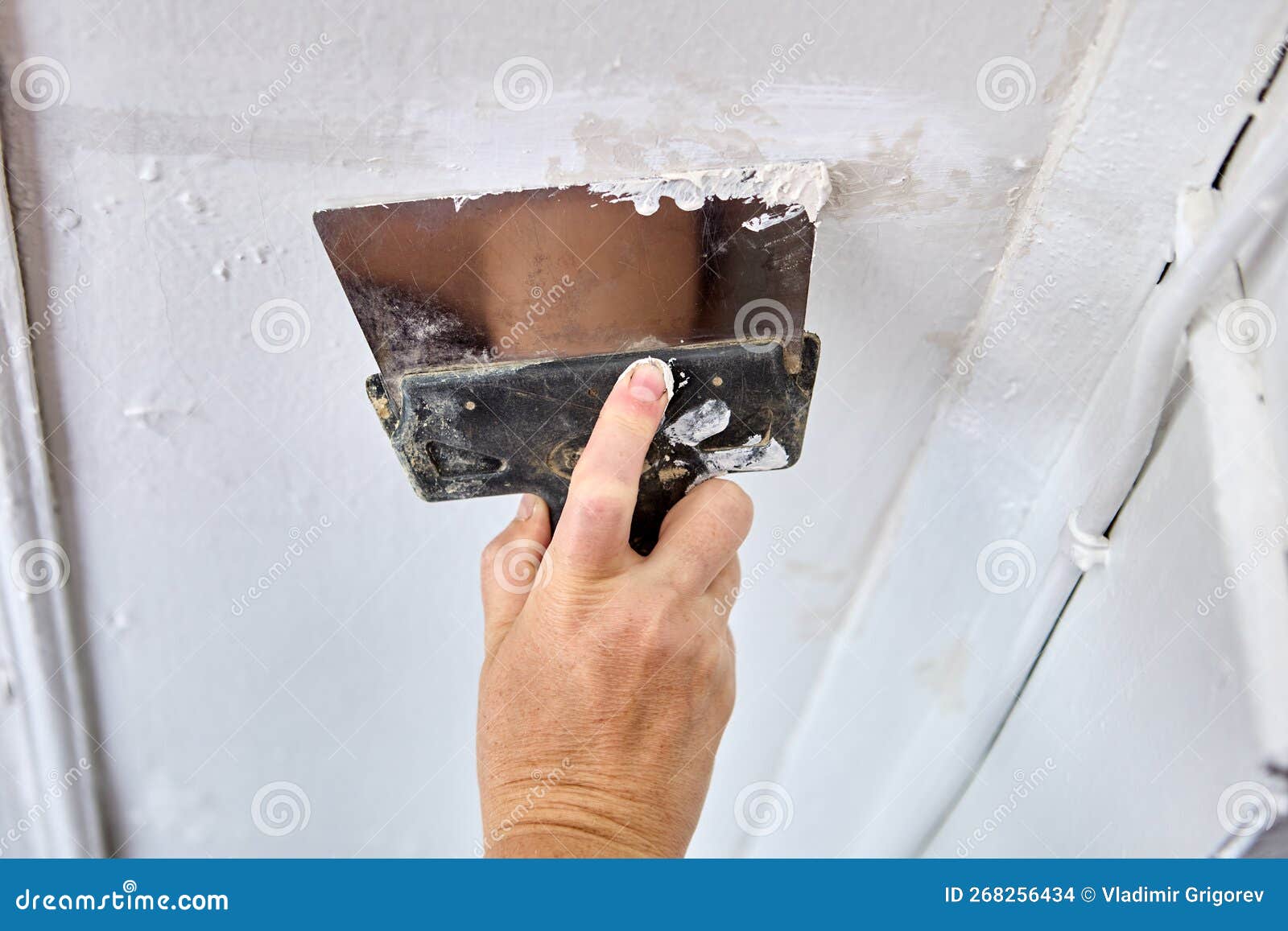 Puttying Ceiling during Finishing Work at Home with Steel Trowel. Stock ...