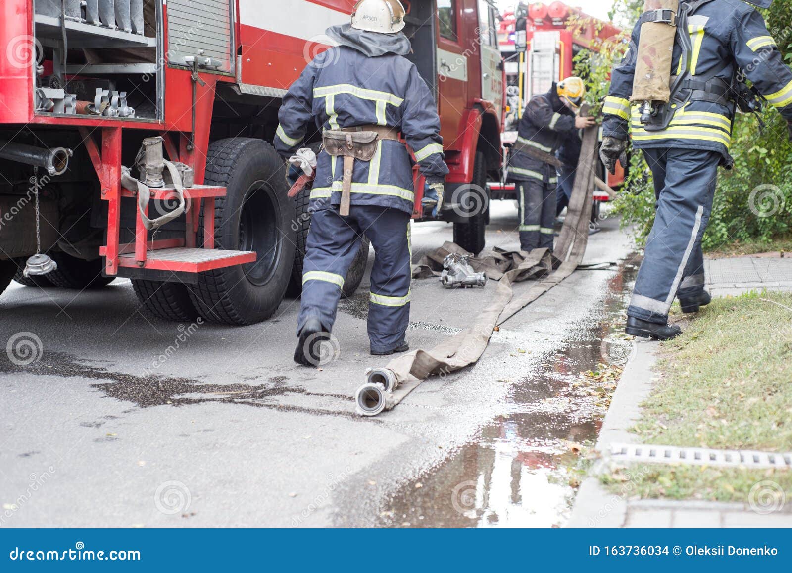 Fire Brigade Works on a Machine with a Hose. View from the Back ...