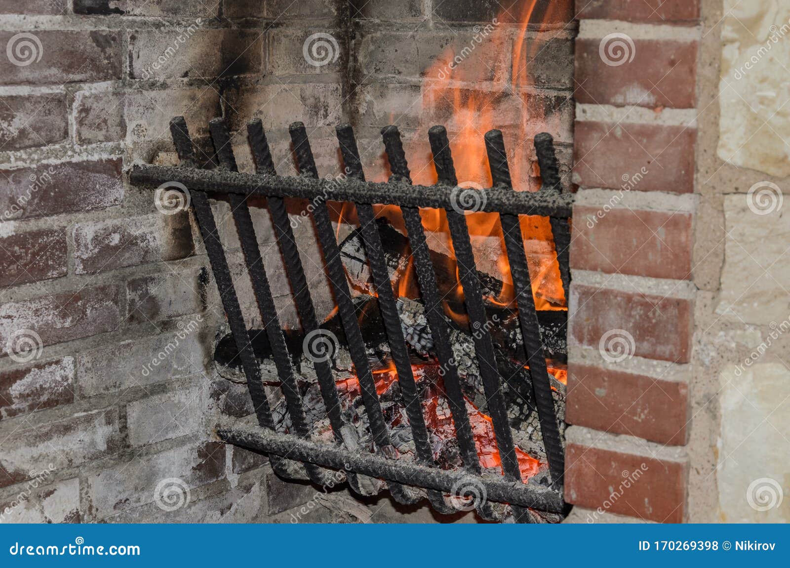 Fire Burns in a Brick Fireplace with a Metal Grate Stock Photo - Image ...