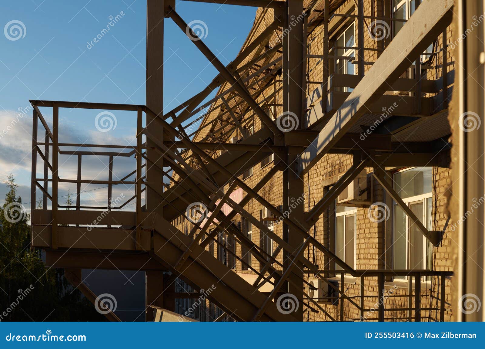 Fire Escape on the Wall of a Yellow Brick House Against a Blue Sky with ...