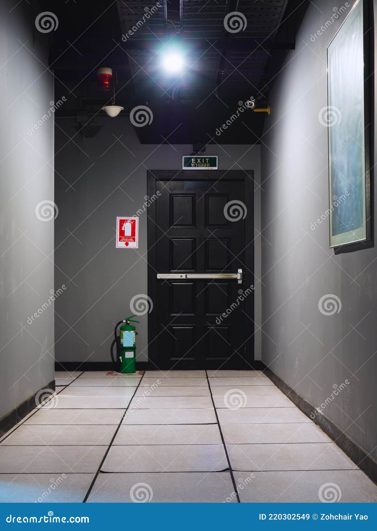 The Fire Exit Has An Exit Sign Above The Door At The End Of The Dimly ...