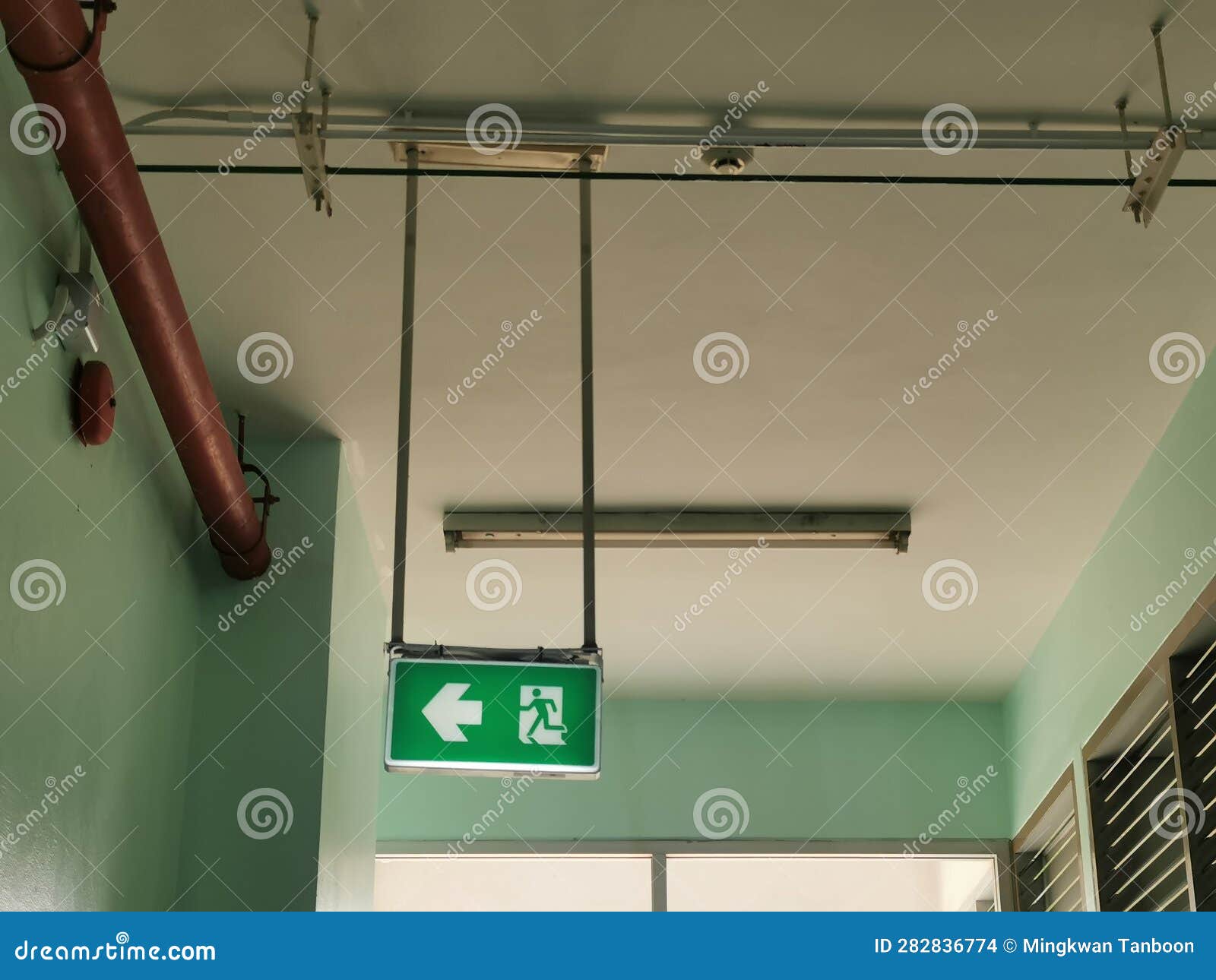 A Fire Exit Sign is Placed at the Top of the Corridor. Stock Photo ...