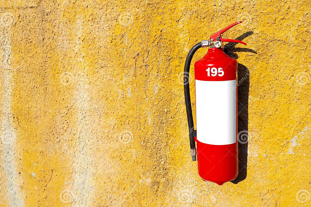 Fire Extinguisher on the Yellow Old Wall Stock Photo - Image of metal ...