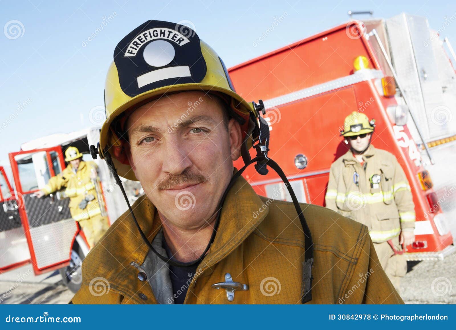 Fire Fighter in Front of Colleagues and Fire Engine Stock Photo - Image ...
