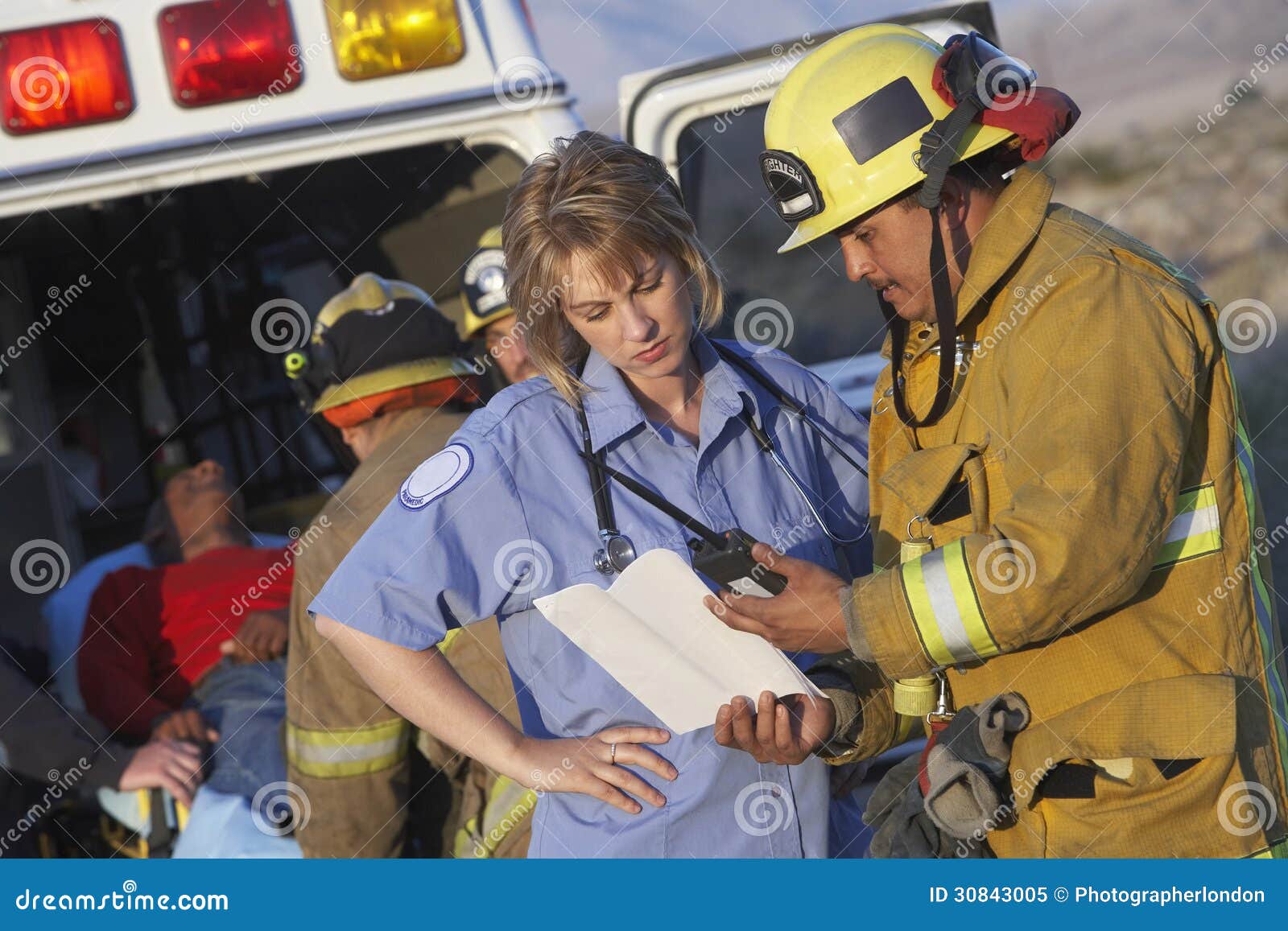 Fire Fighters and Paramedics Assisting Injured Man Stock Image - Image ...